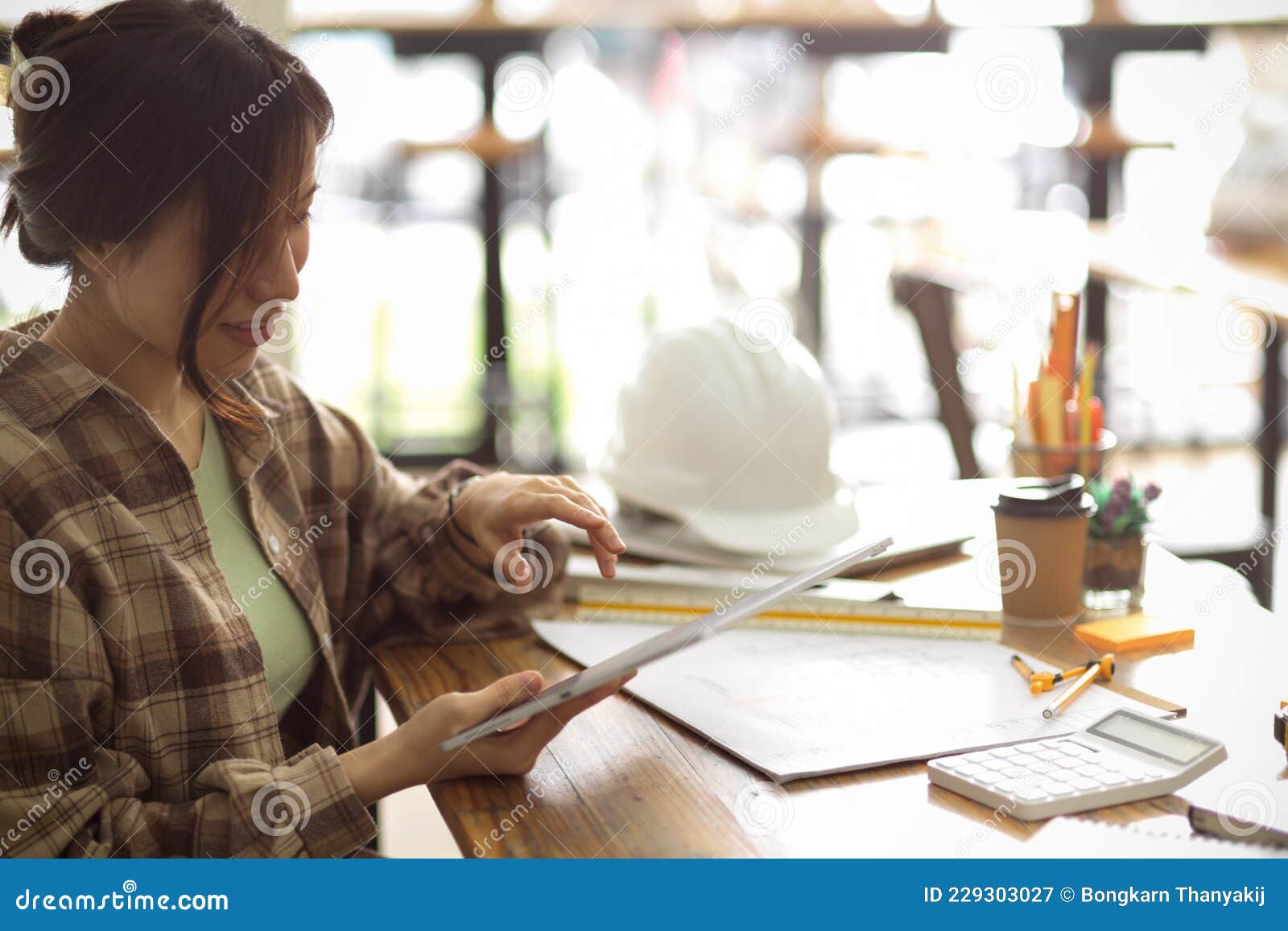 Female Architecture Looking Building Scale and Plan on Digital Tablet ...