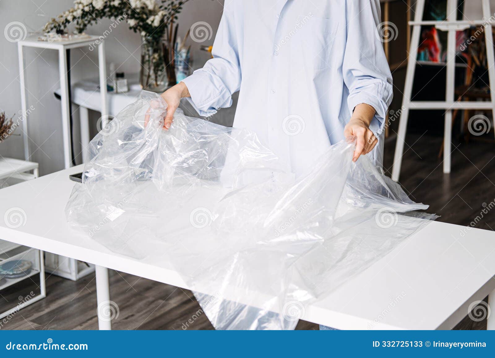 Female Artist Preparing Workspace with Plastic Sheet, Art Studio Setup ...