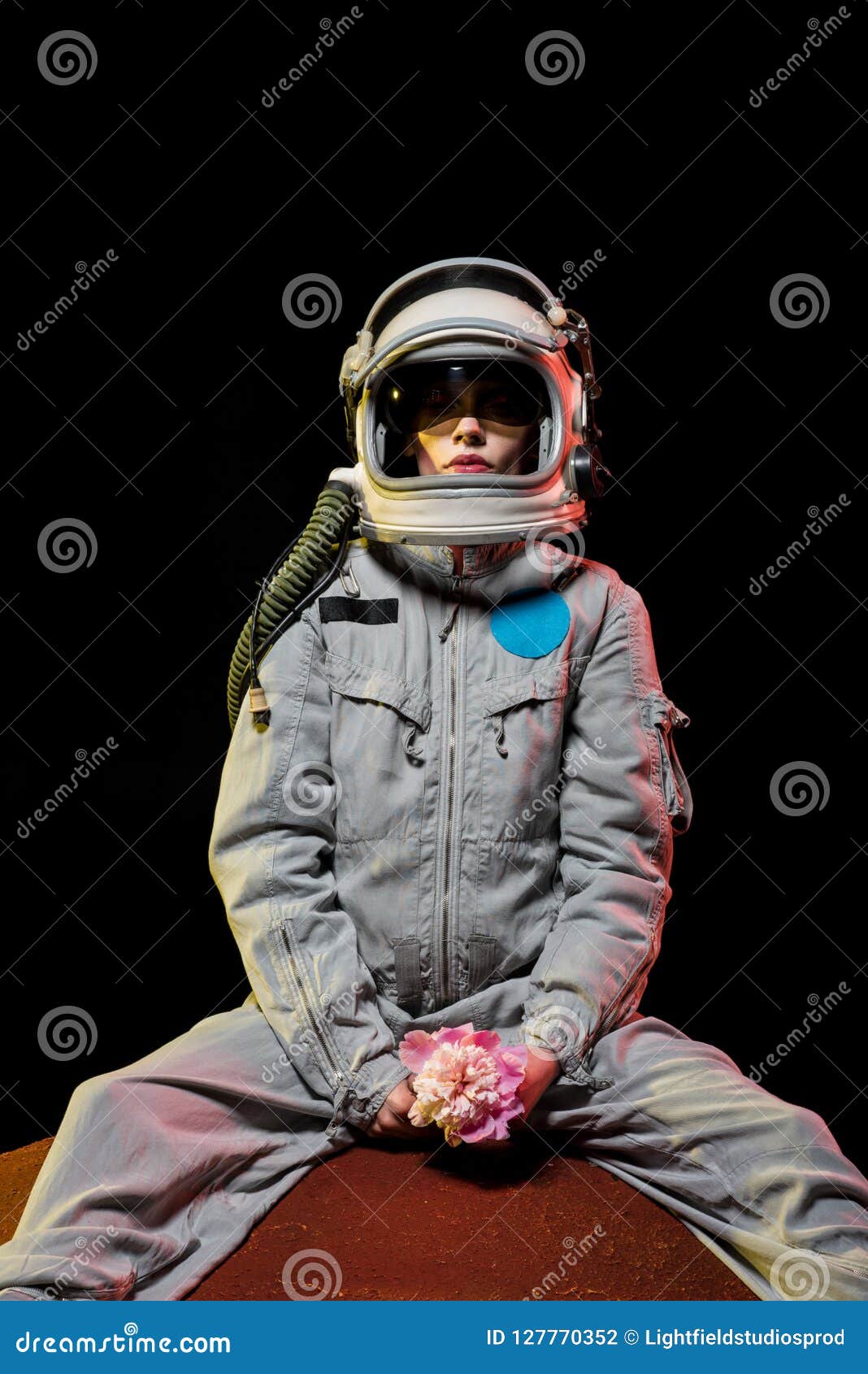 Female Astronaut in Spacesuit and Helmet Sitting on Planet with Flower ... Female Astronaut in Spacesuit and Helmet Sitting on Planet with Flower ...