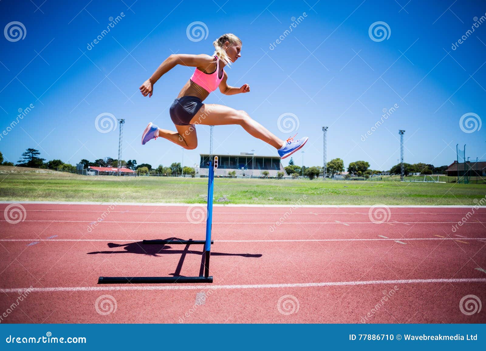 Female Athlete Jumping Above the Hurdle Stock Photo - Image of ...
