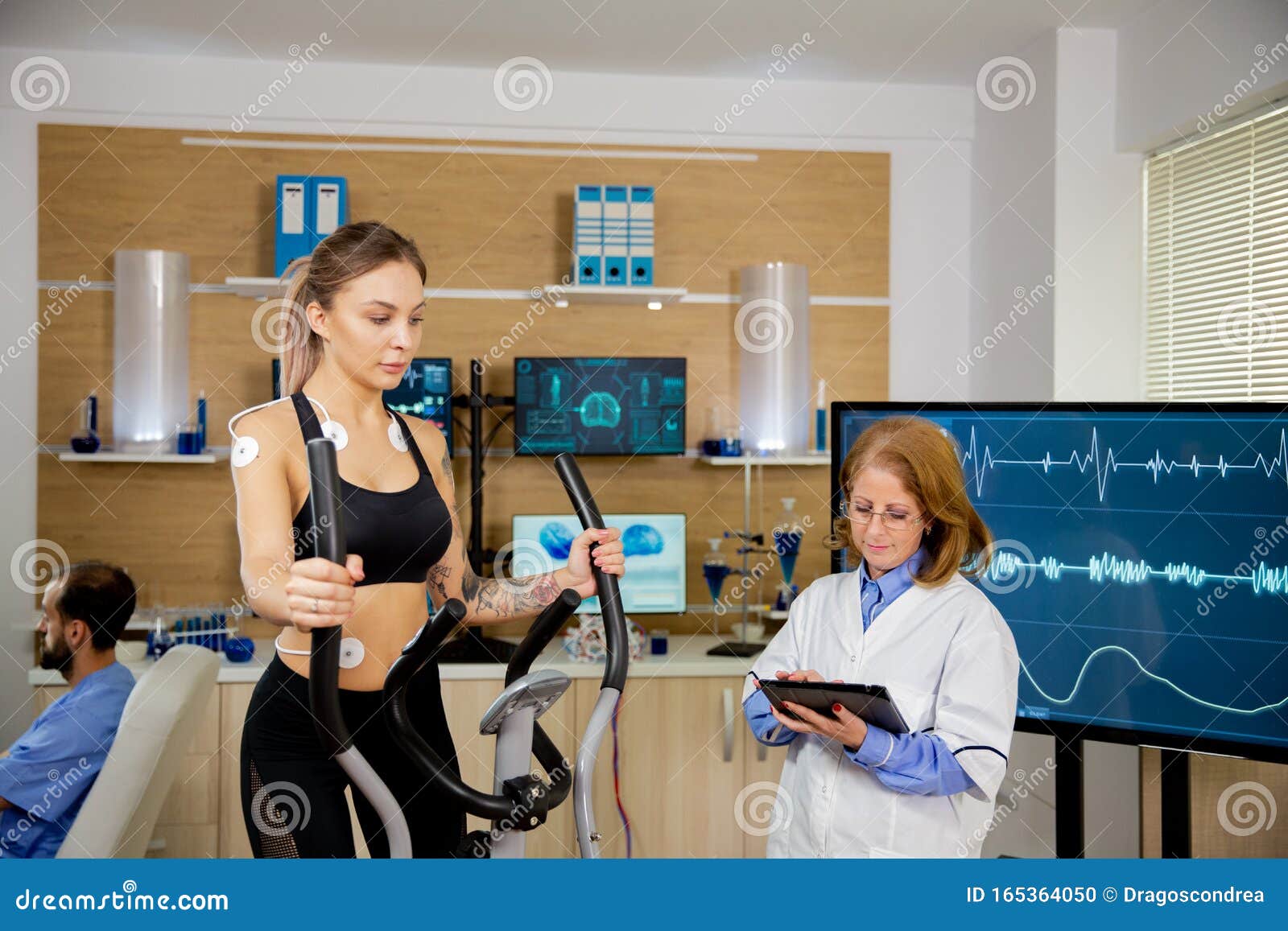 Female Athlete Running Tests on the Stepper and Doctor Making Notes in ...