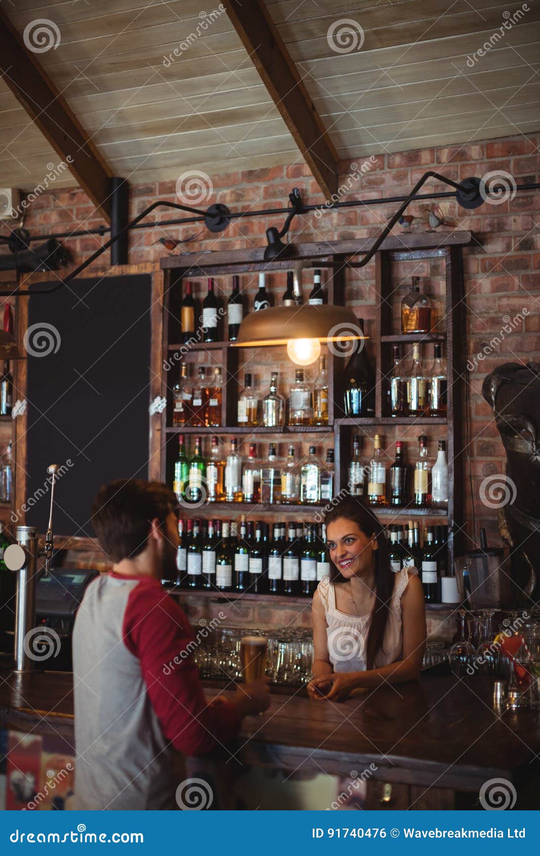 Female Bar Tender Interacting with Customer Stock Photo - Image of ...