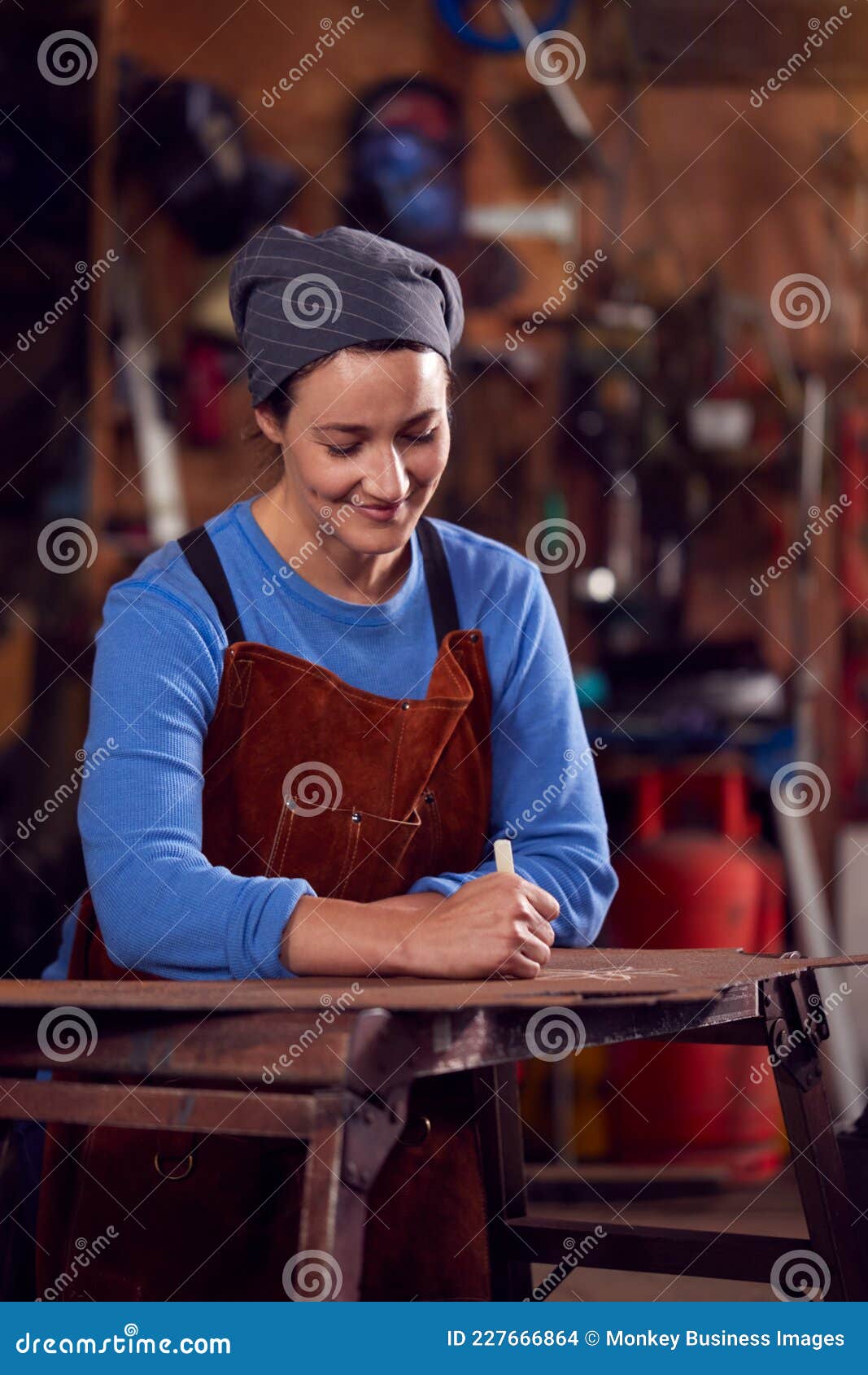 Female Blacksmith Wearing Headscarf Working on Design in Forge Stock ...