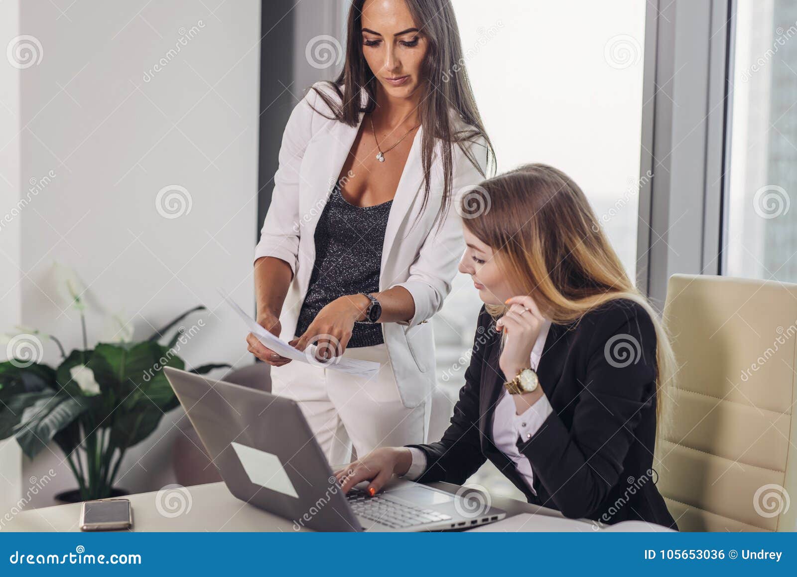 Female Boss Showing Documents To Personal Assistant Giving Instructions And Tasks Stock