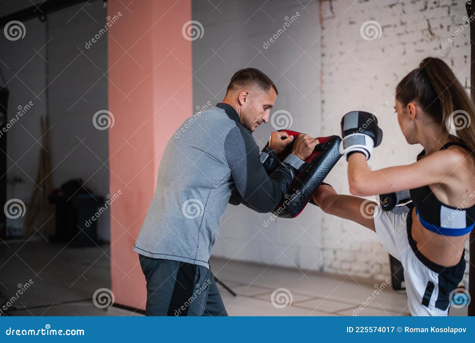 Female Boxer Practicing Hits with Her Personal Trainer in a Boxing ...