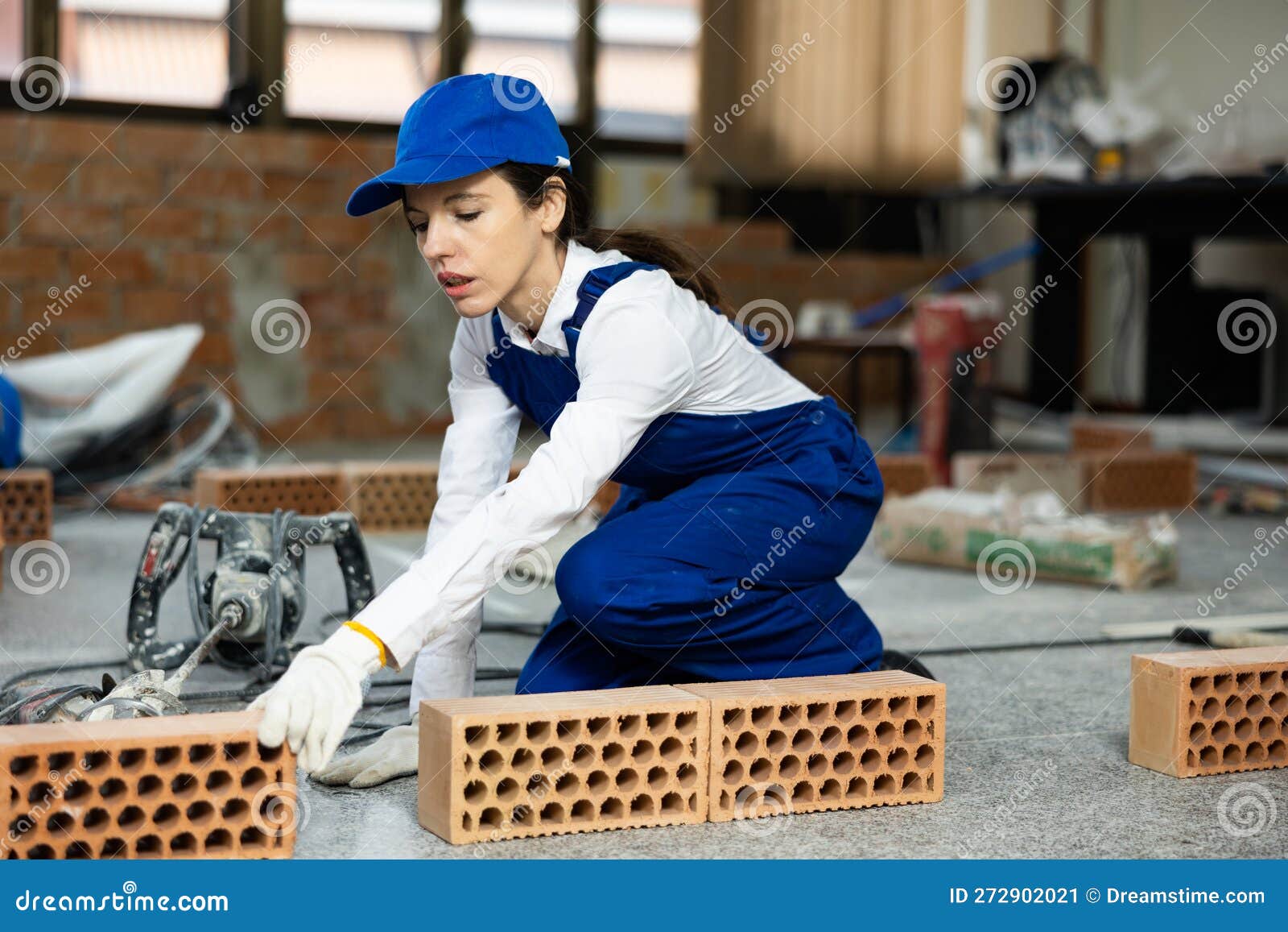 Female Builder Arranging Bricks Inside Building Under Construction ...