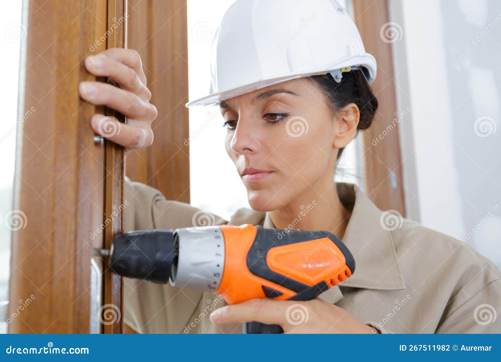 Female Builder Using Cordless Drill on Wooden Frame Stock Photo - Image ...
