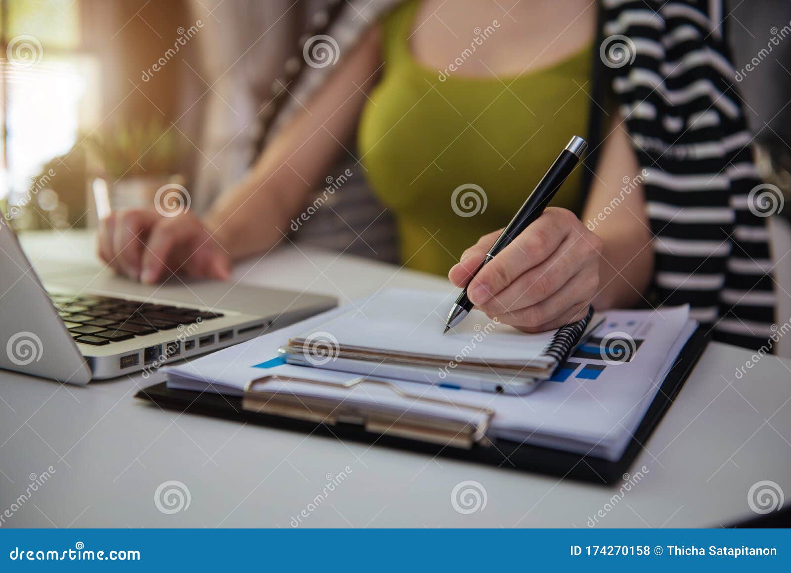 Female Businessman Use a Laptop Computer and Take Notes in the Notebook ...