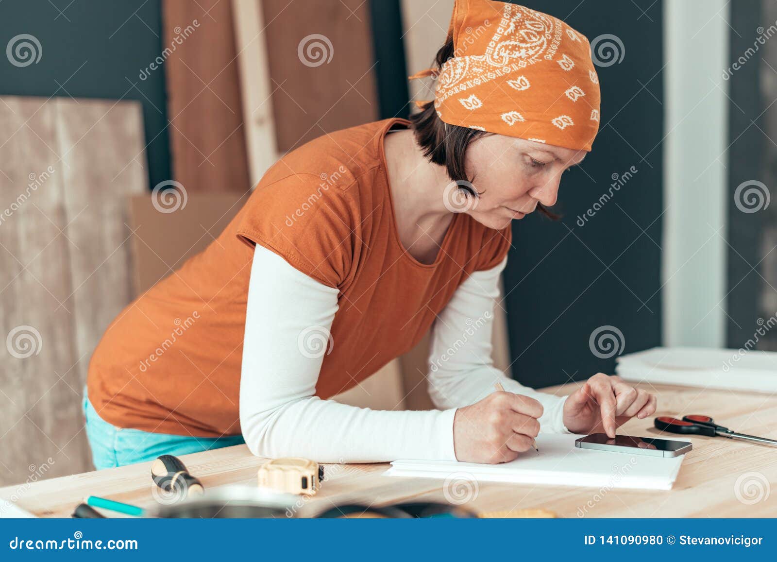 Female Carpenter Doing Financial Calculation Stock Photo - Image of ...