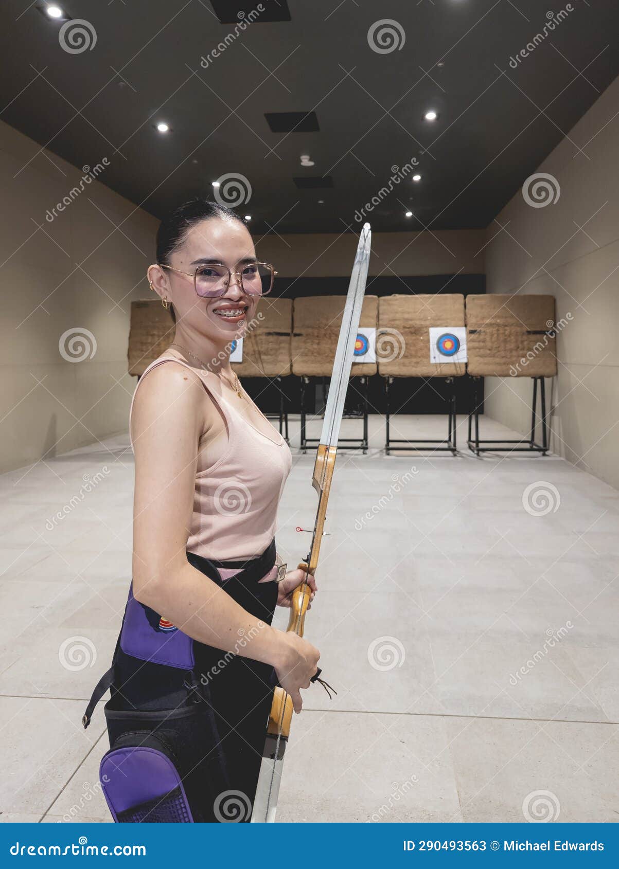 A Female Casual Hobbyist Doing Target Practice at an Indoor Archery ...