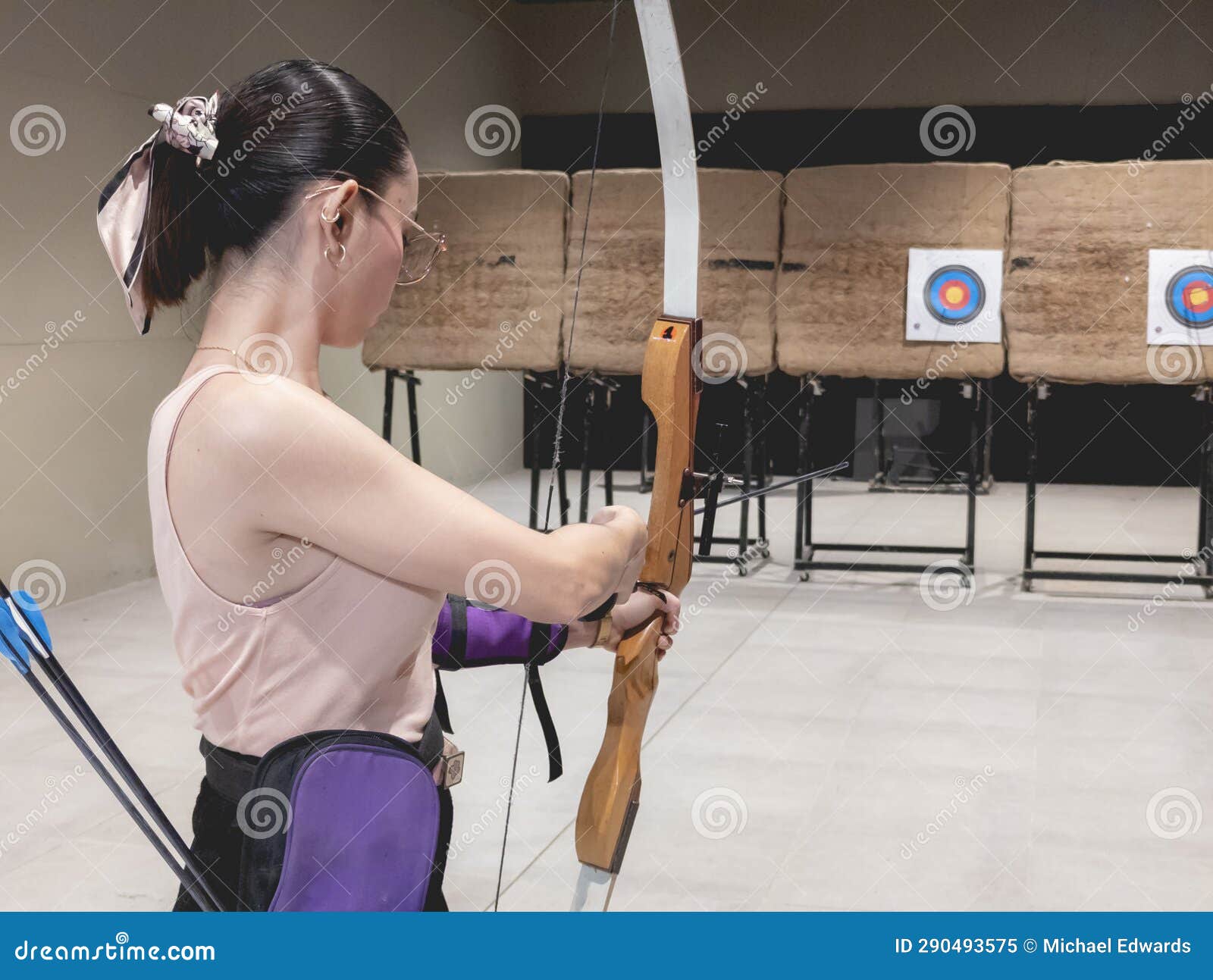 A Female Casual Hobbyist Doing Target Practice at an Indoor Archery ...
