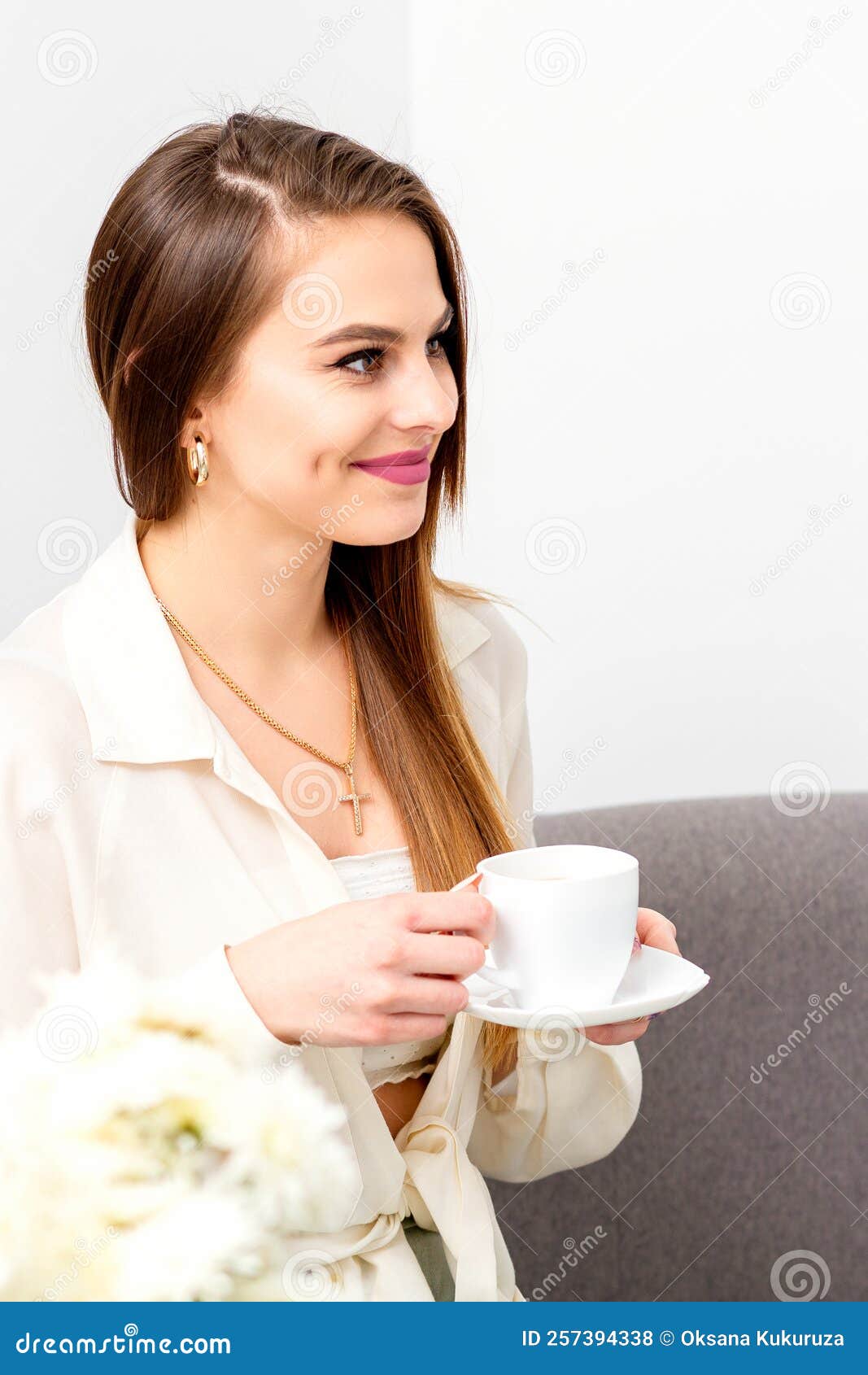 Female Caucasian Client with a Cup of Coffee in His Hands Smiling at a ... Female Caucasian Client with a Cup of Coffee in His Hands Smiling at a ...