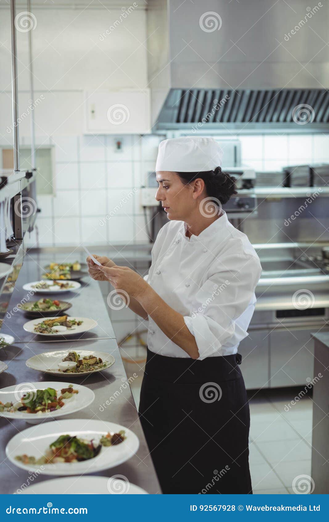 Female Chef Looking at an Order List in the Commercial Kitchen Stock ...