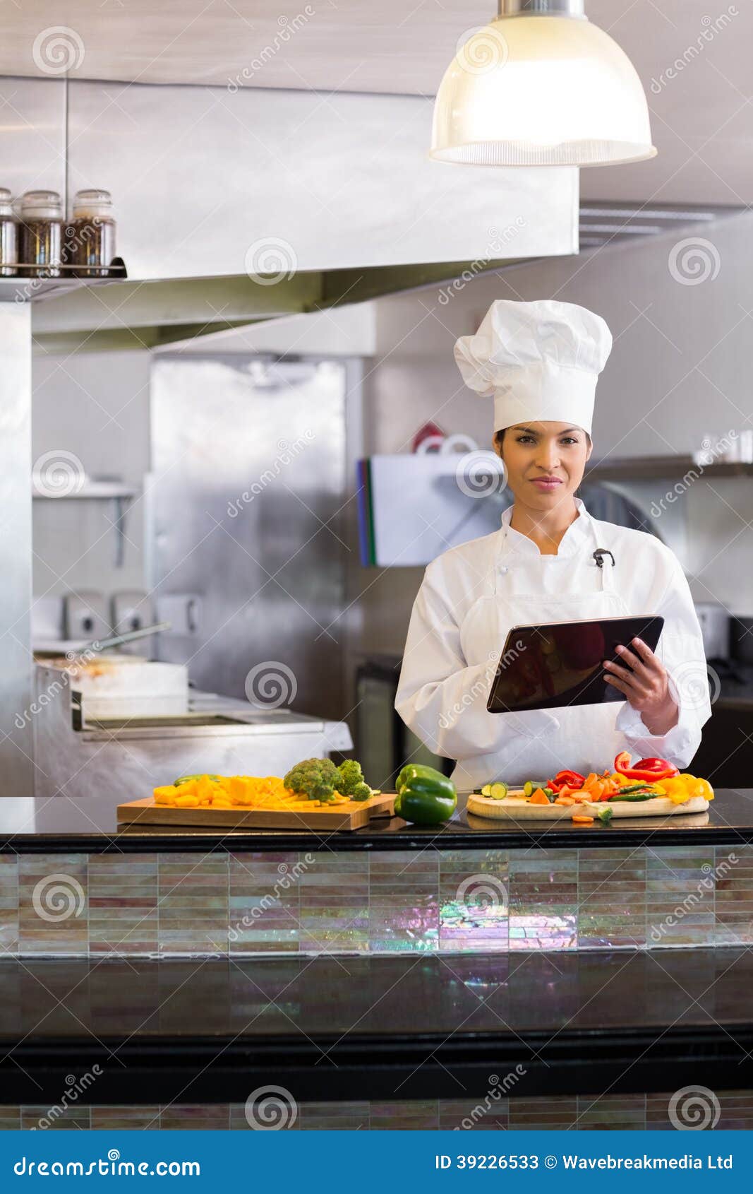 Female Chef Using Digital Tablet while Cutting Vegetables in Kitchen ...