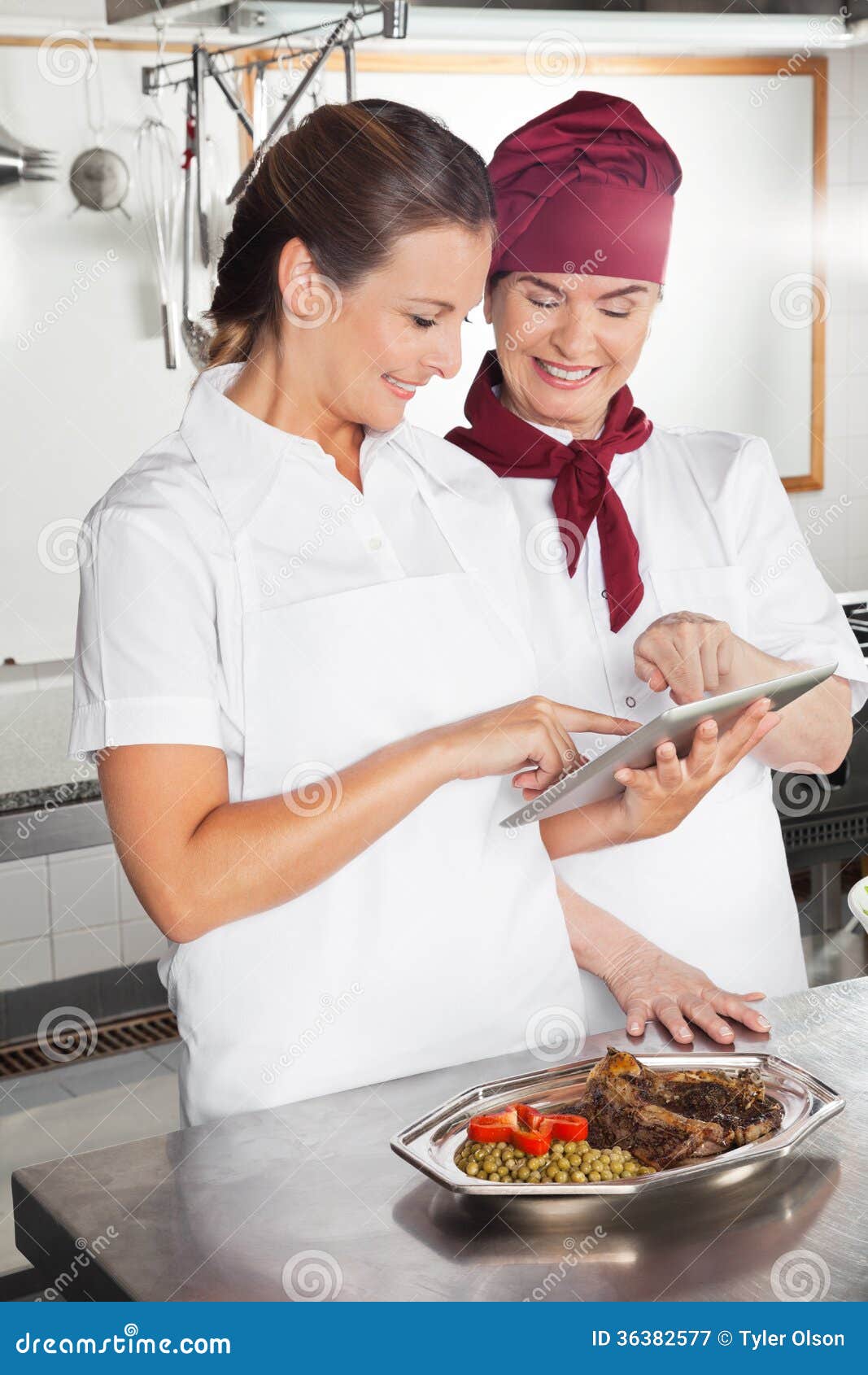 Female Chefs Using Digital Tablet in Kitchen Stock Image - Image of ...