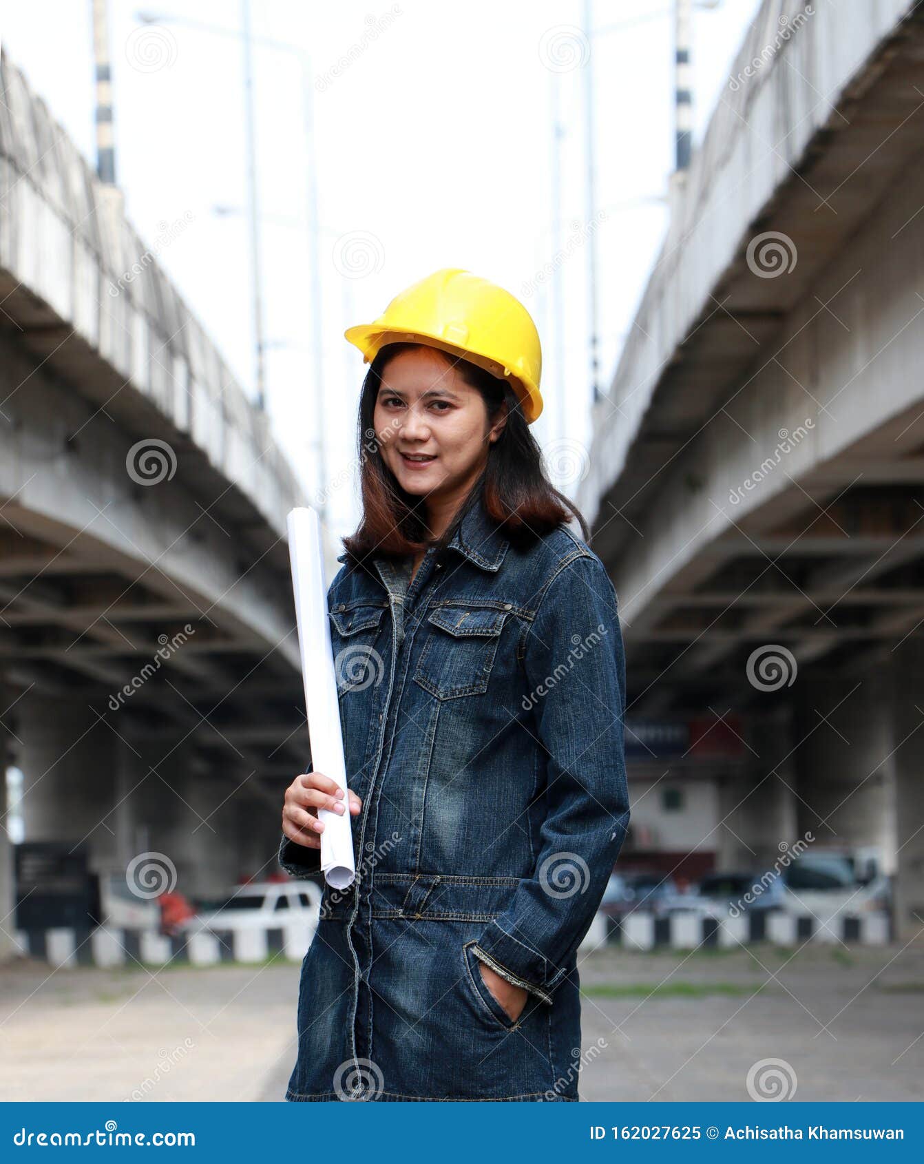 Female Civil Engineer with Yellow Helmet, Standing with Project Drafts ...