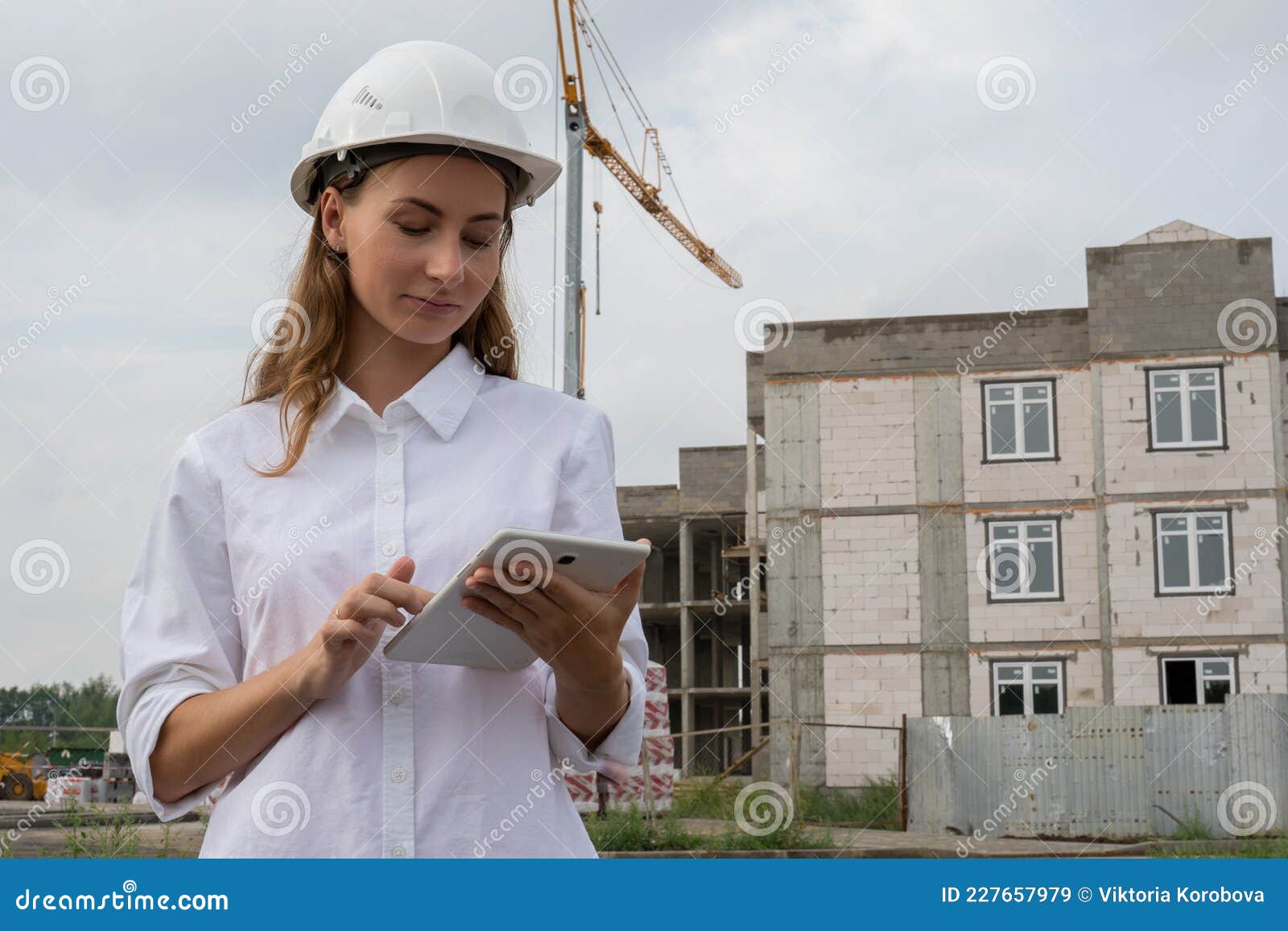 Female Civil Engineer Using a Tablet at Her Workplace on a Construction ...