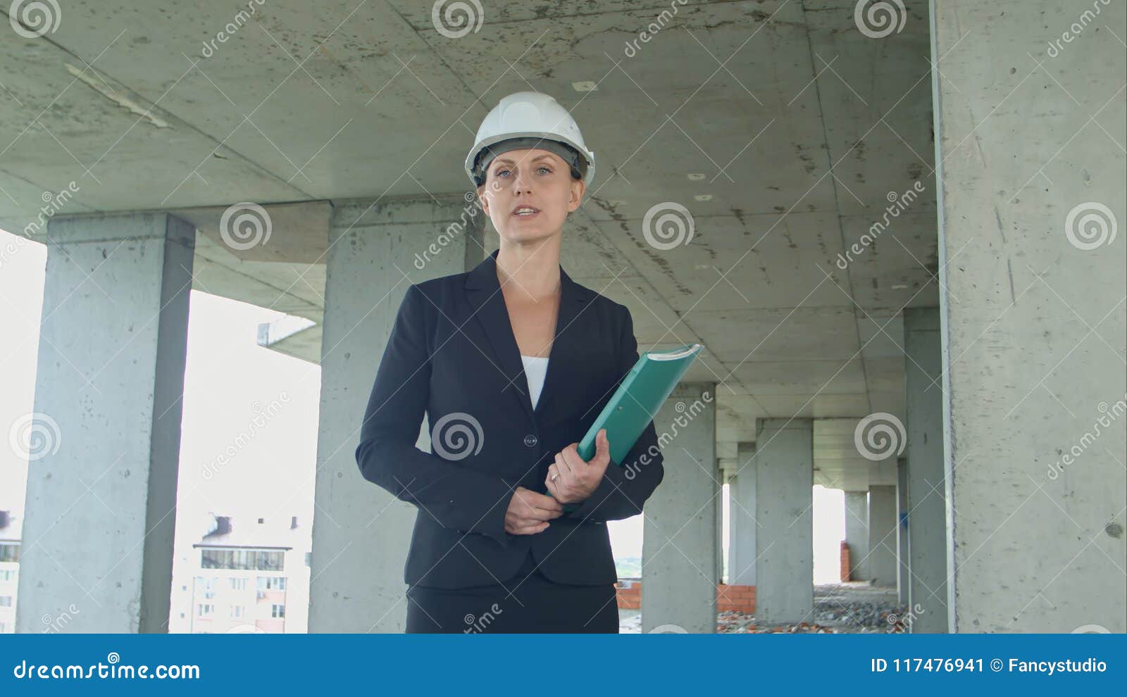Female Construction Manager with Blueprint on Building Site Presenting ...