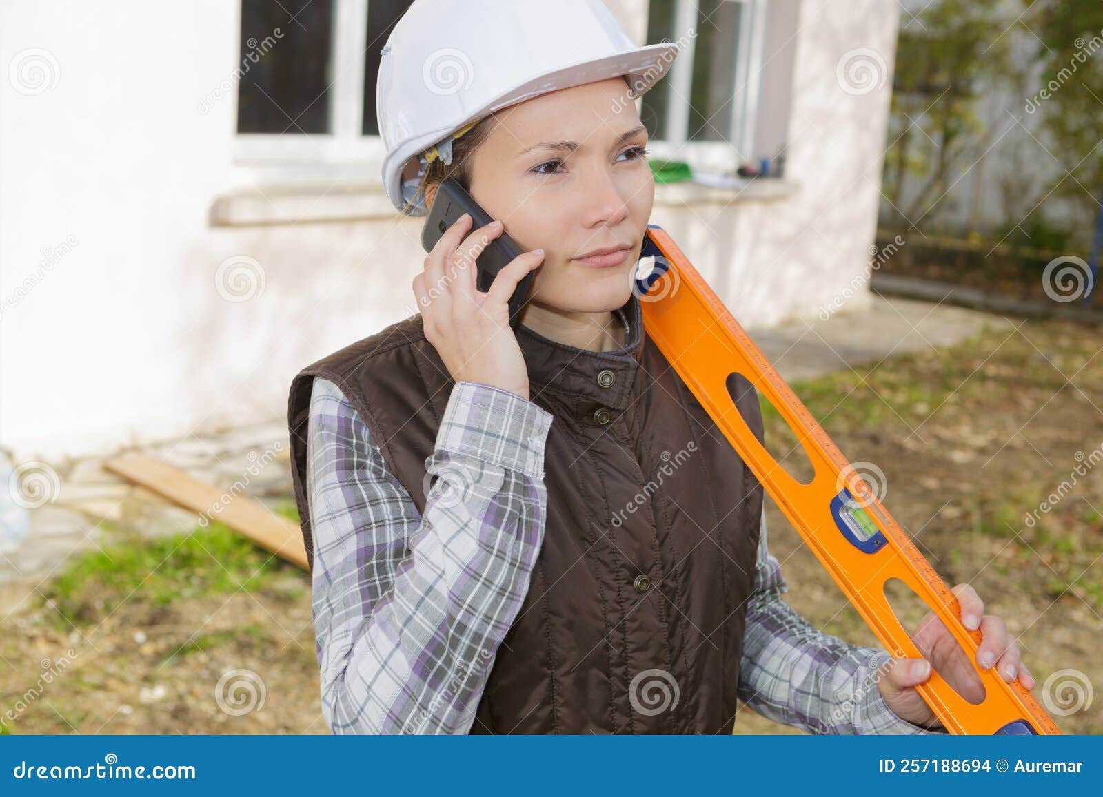 Female Construction Worker with Level Outside Construction Site Stock ...