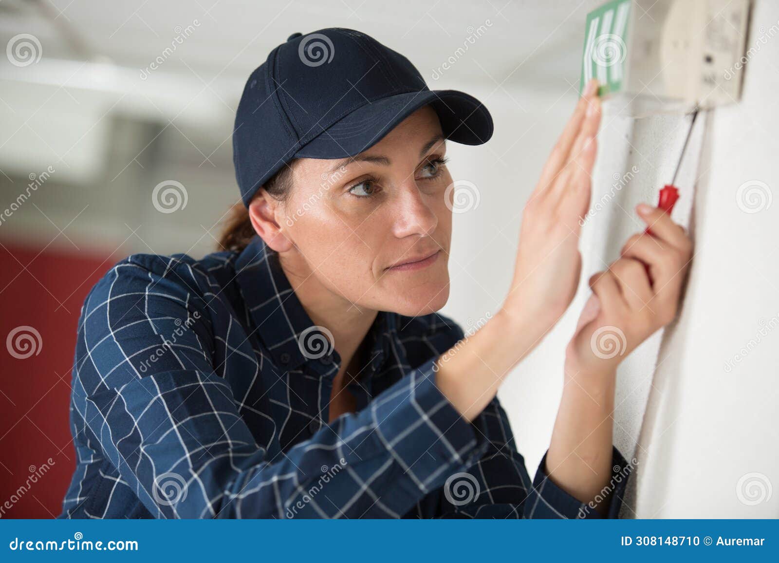 Female Contractor Installing Illuminated Exit Sign Stock Photo - Image ...