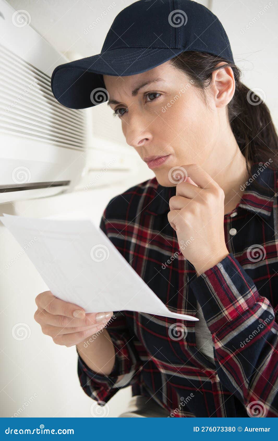 Female Contractor Reading Instructions for Programming Air Conditioning ...