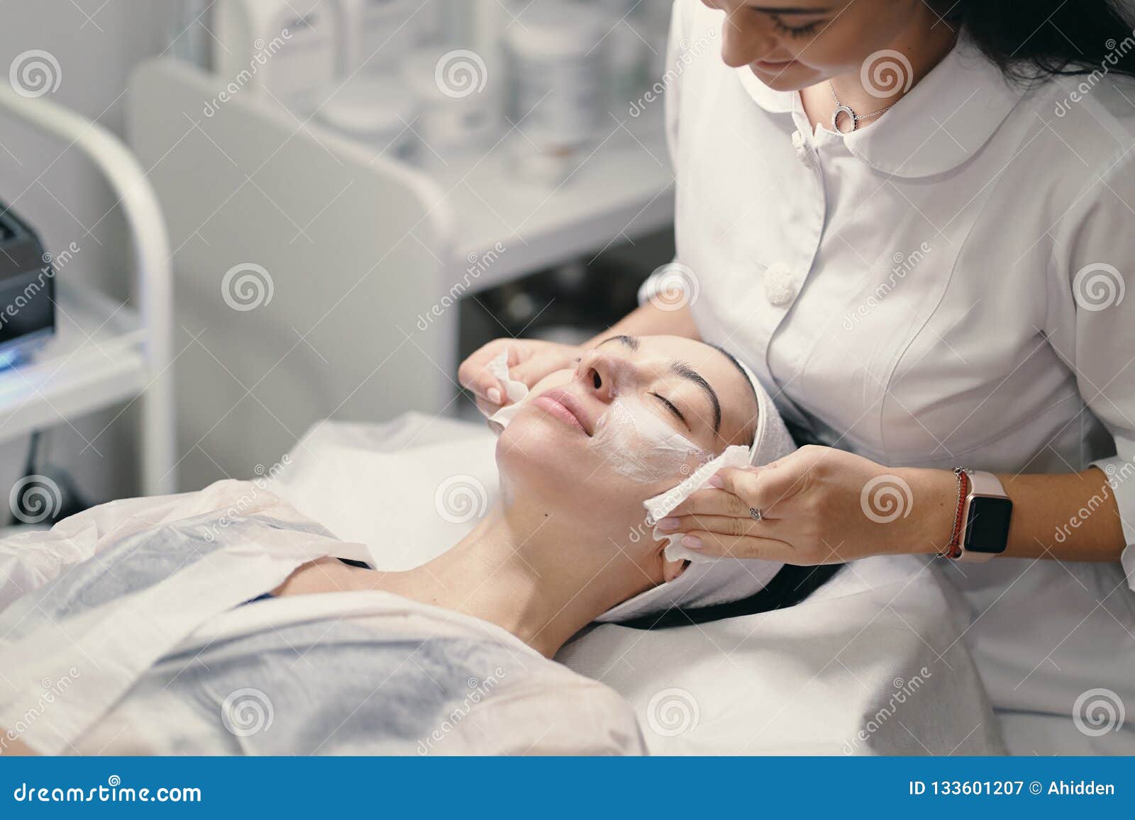 Female Cosmetologist Making Facial Treatment To A Beautiful Woma Stock