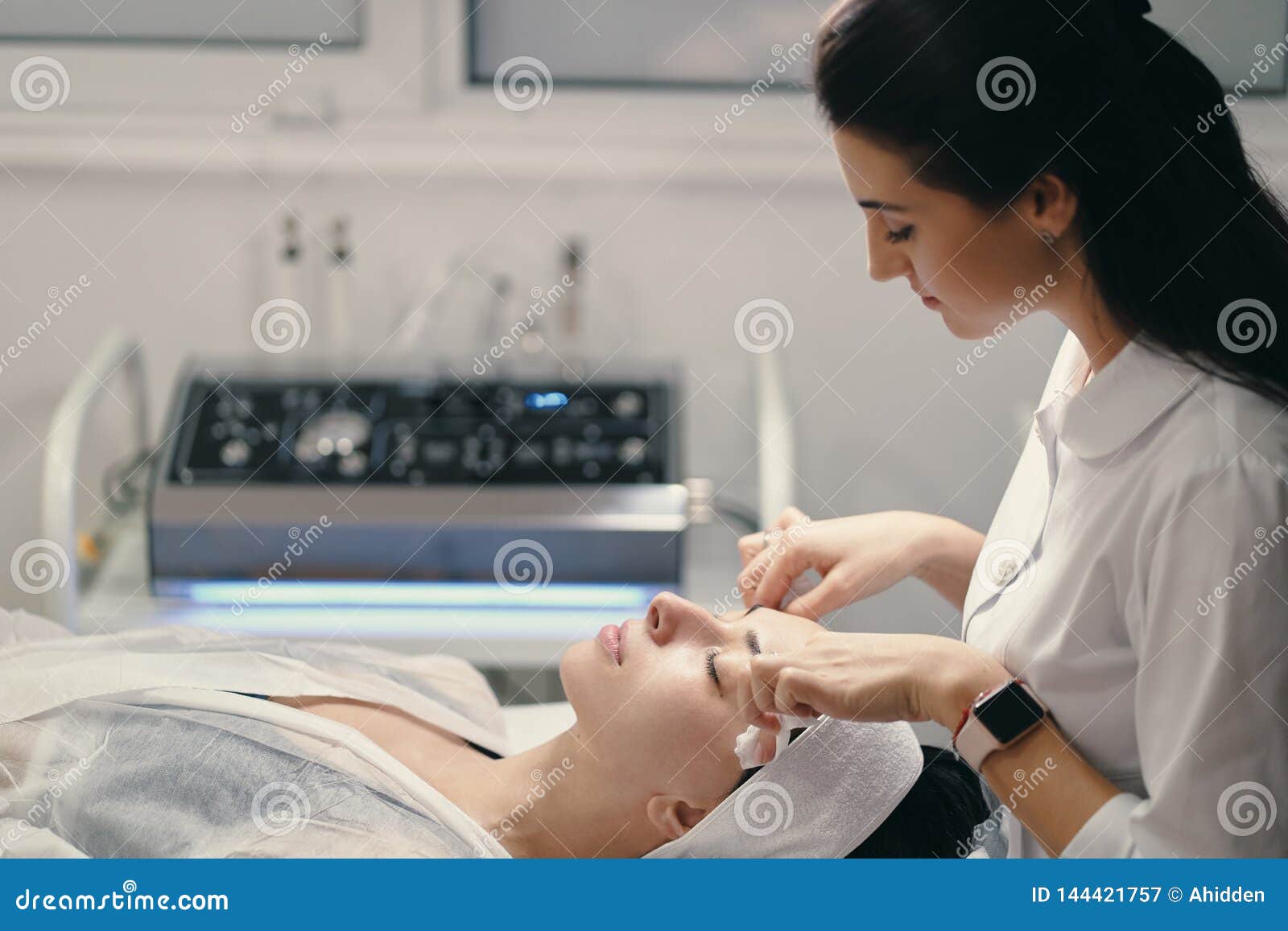 Female Cosmetologist Making Facial Treatment To A Beautiful Woma Stock