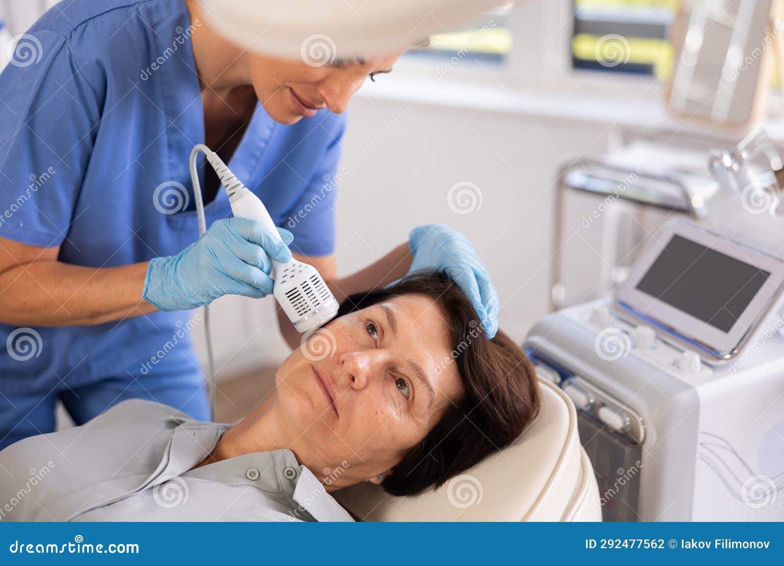 Female Cosmetologist Performing Female Face Skin Massage Procedure In