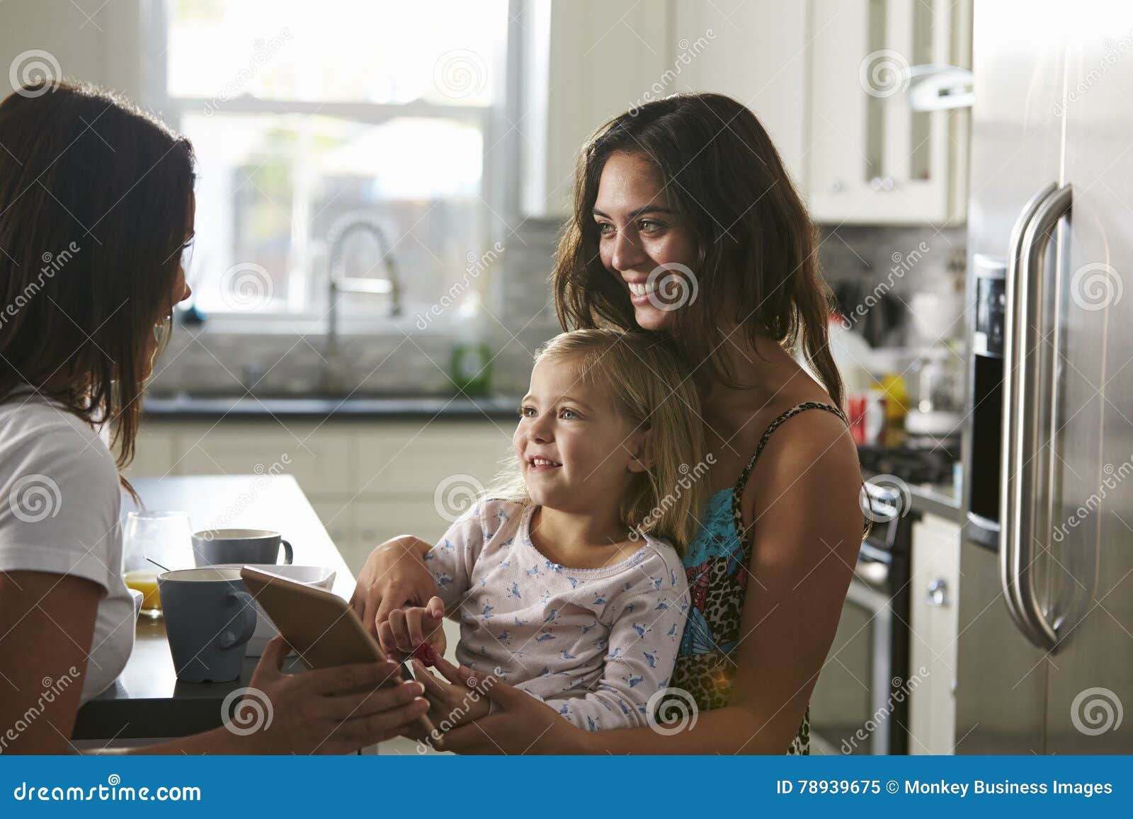 Female Couple Talking in the Kitchen with Their Daughter Stock Image ...