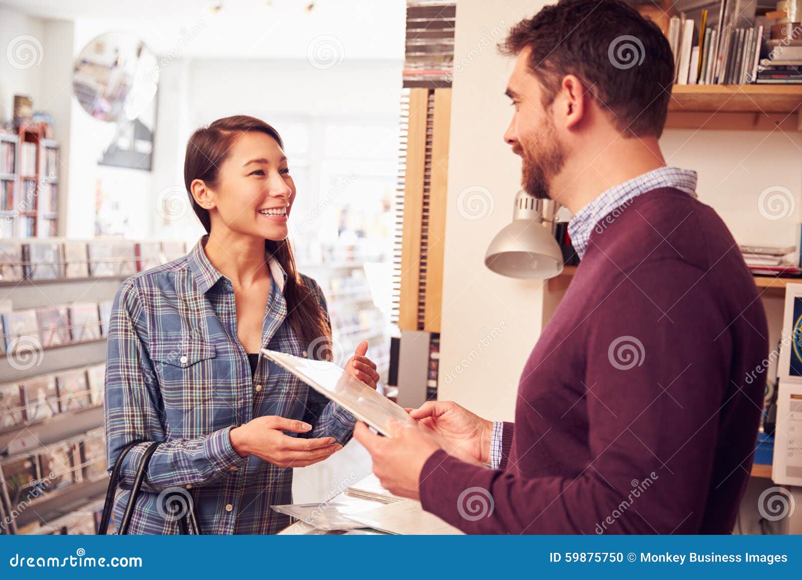 Female Customer Being Served at the Counter of a Record Shop Stock ...