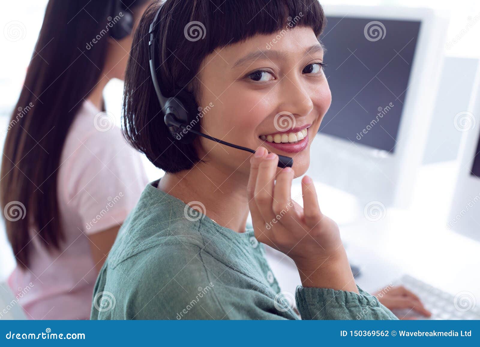 Female Customer Service Executive Working on Computer at Desk in Office ...