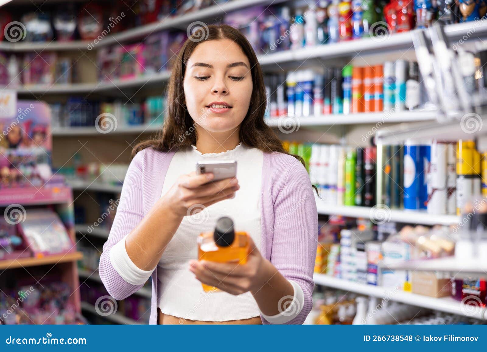 Female Customer Takes a Photo Using a Mobile Phone in Cosmetics Store ... Female Customer Takes a Photo Using a Mobile Phone in Cosmetics Store ...