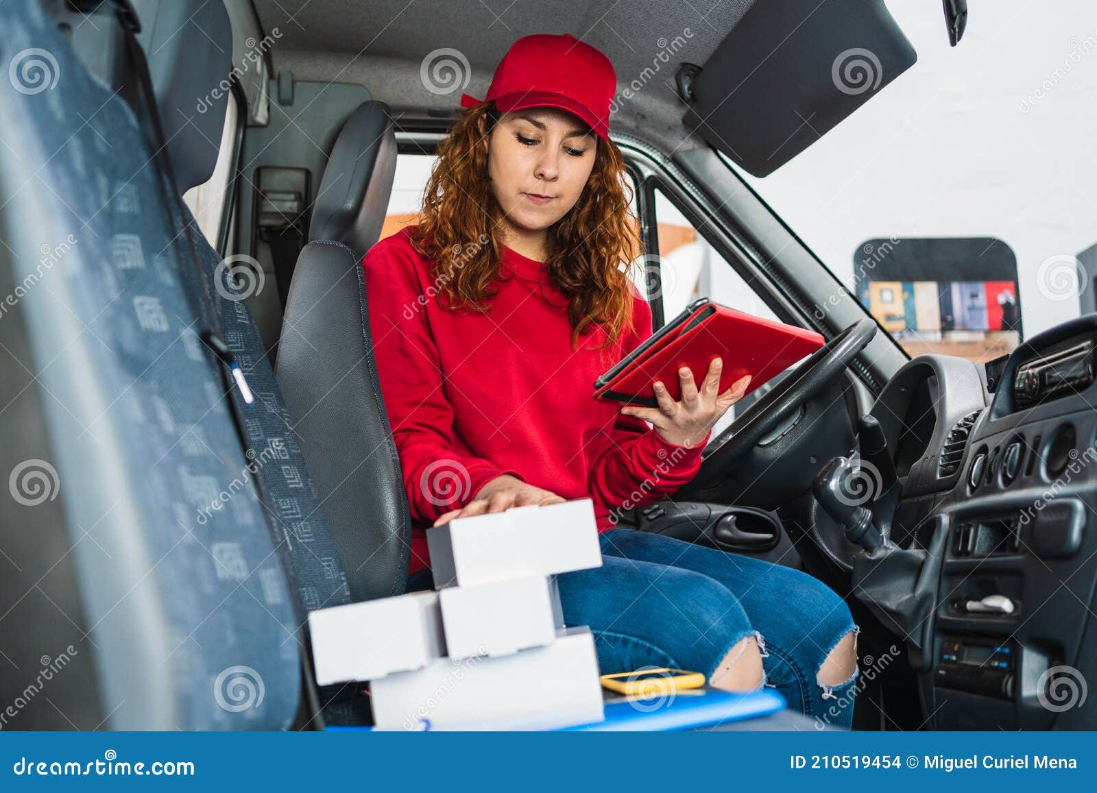 Female Delivery Driver Tracking Packages on a Tablet in the Van Stock ...