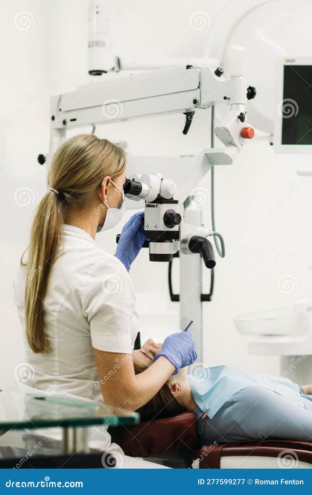 Female Dentist Using Dental Microscope Treating Patient Teeth at Dental ...