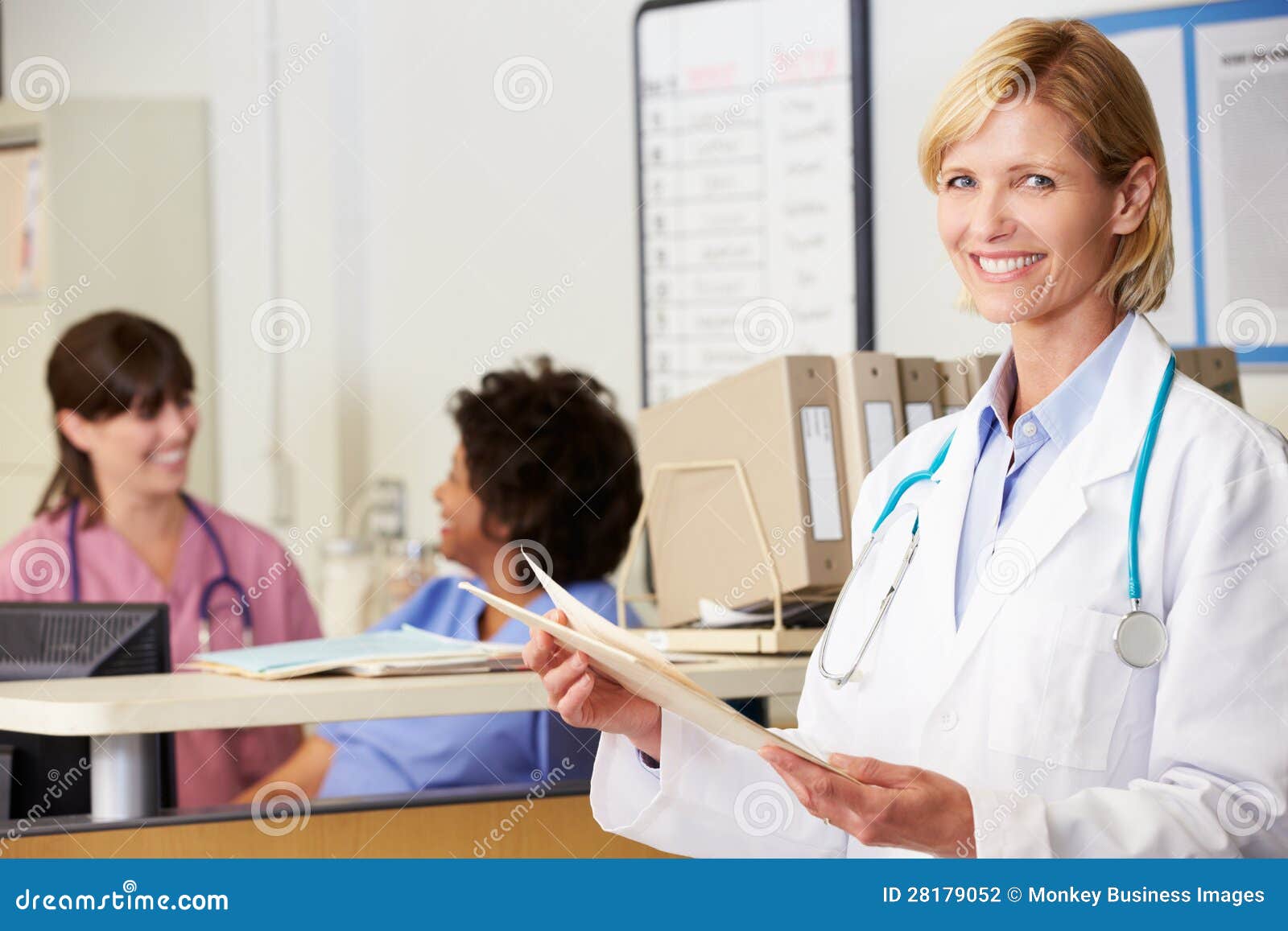 Female Doctor Reading Patient Notes at Nurses Station Stock Photo ...