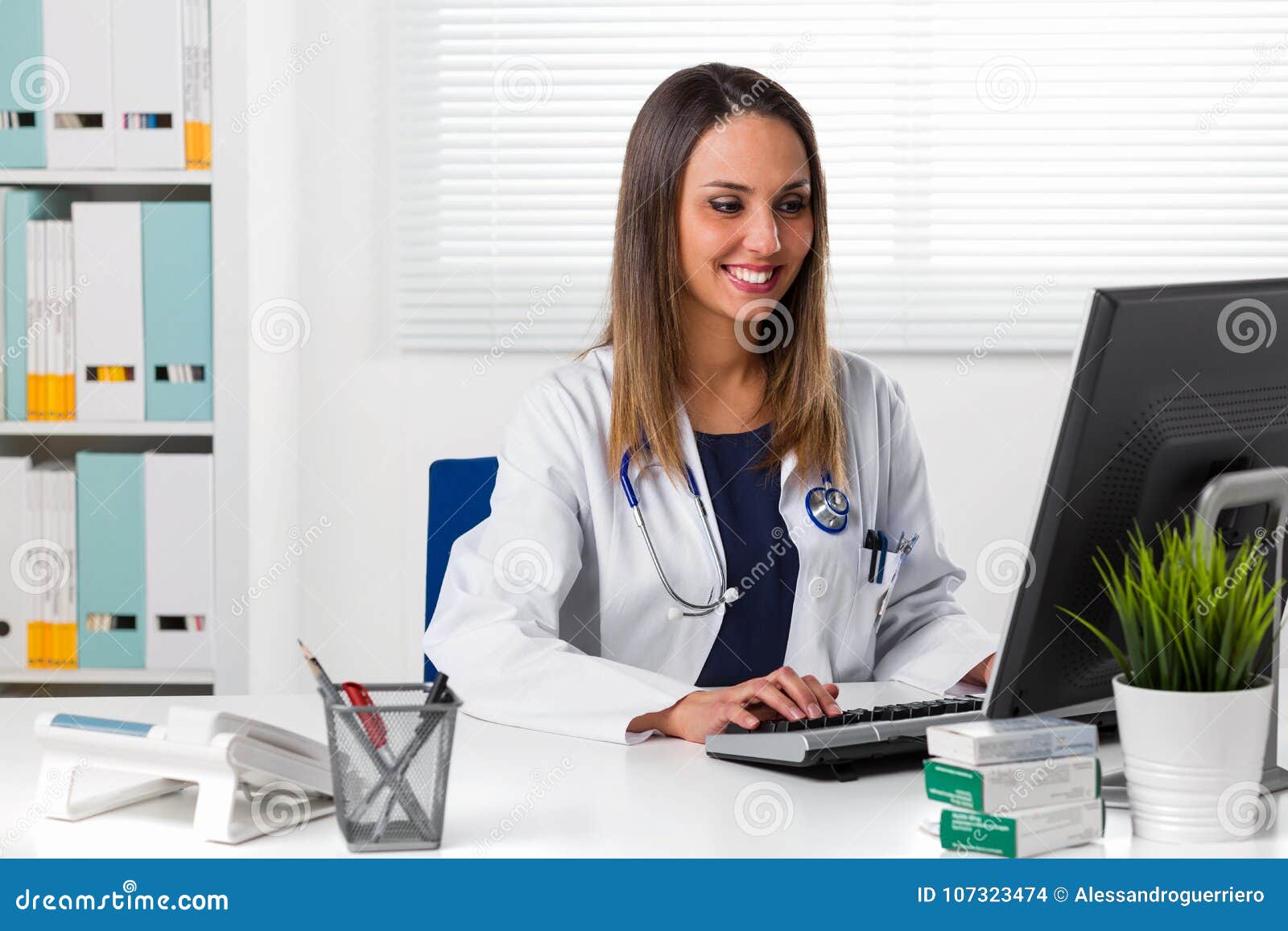 Female Doctor Sat at Desk Using Computer Stock Photo - Image of ...