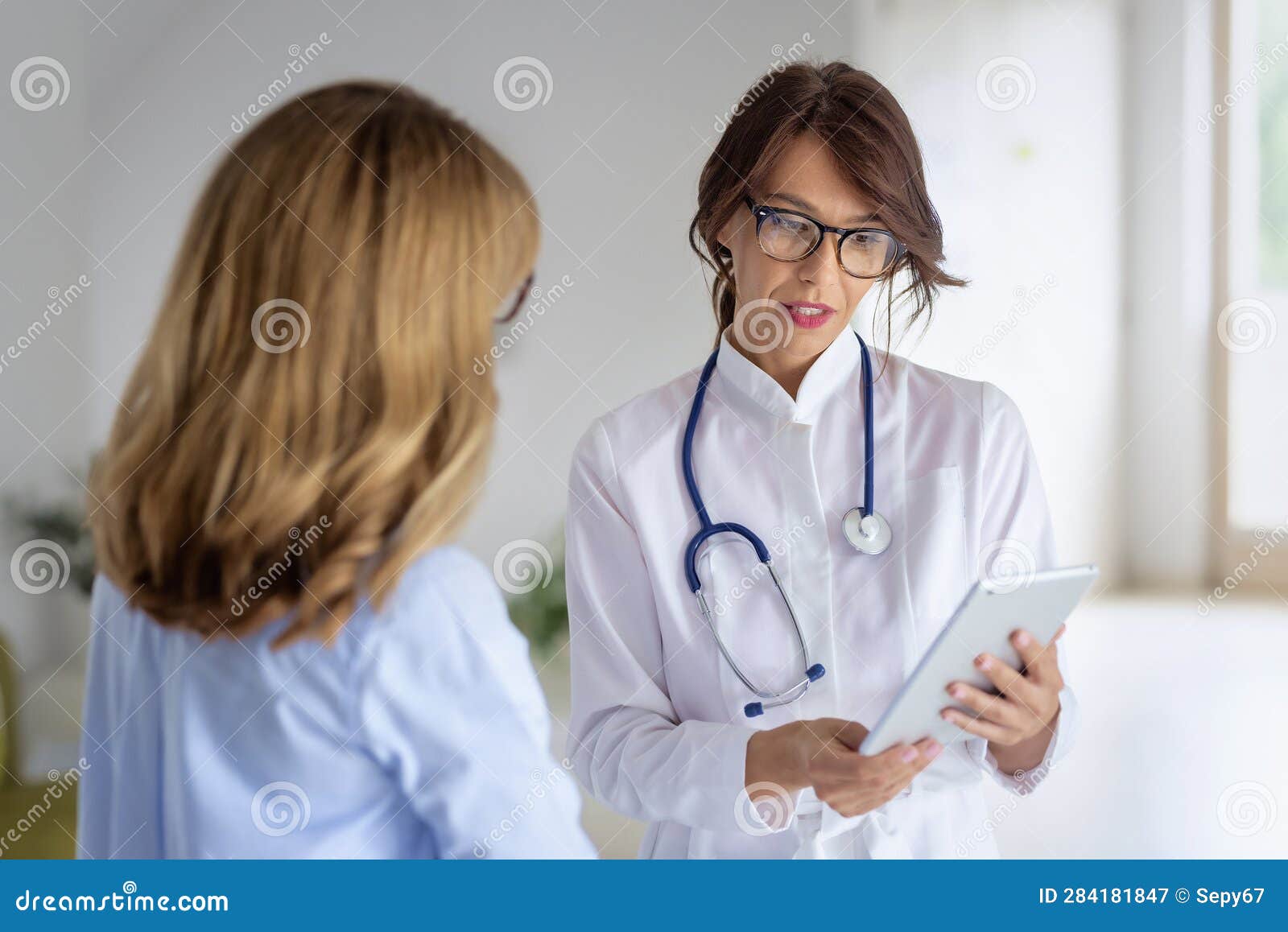 Female Doctor Standing on the Corridor Explaining Symptoms To the ...