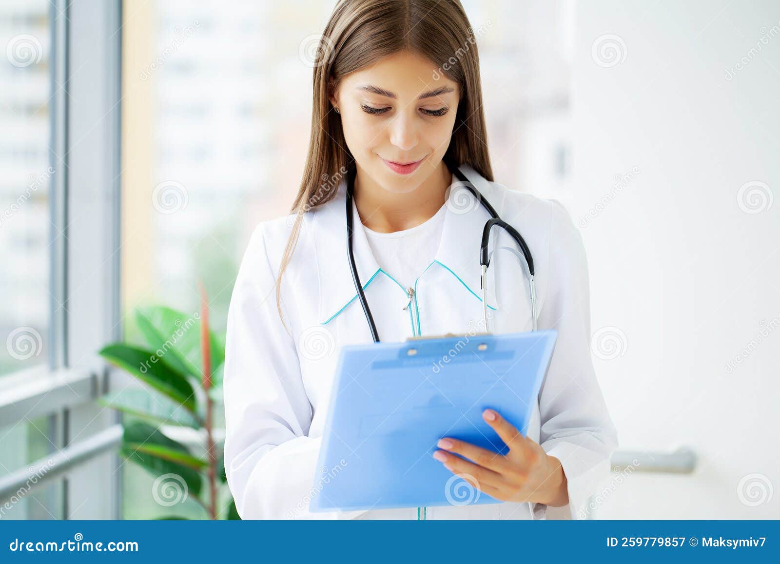 Female Doctor in Surgery Reading Patient Notes Stock Image - Image of ...