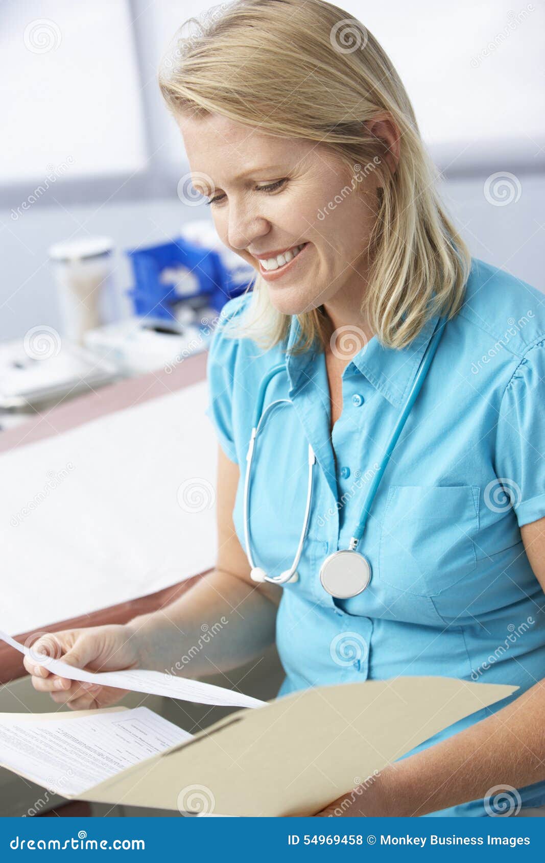 Female Doctor in Surgery Reading Patient Notes Stock Photo - Image of ...