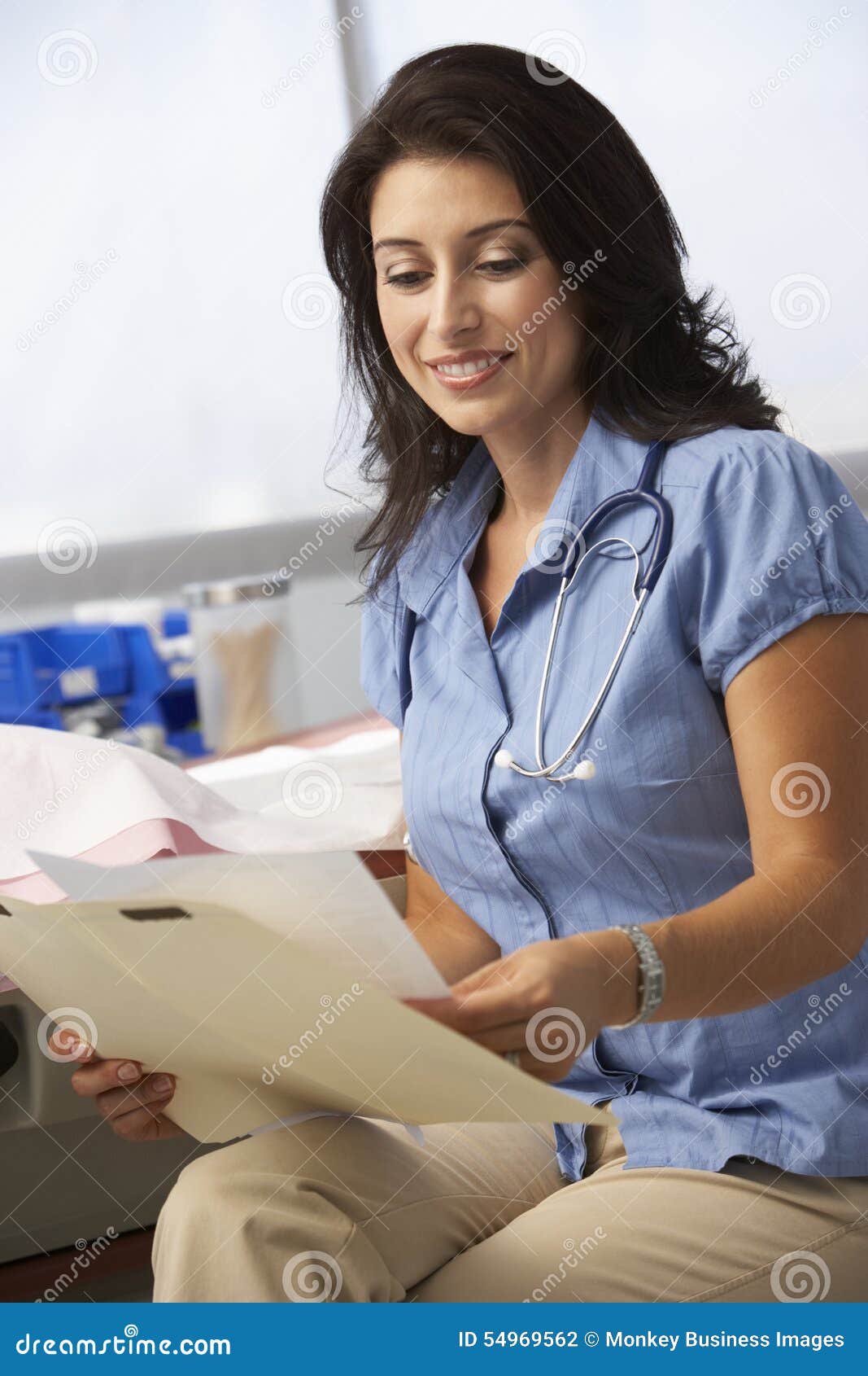Female Doctor in Surgery Reading Patient Notes Stock Photo - Image of ...