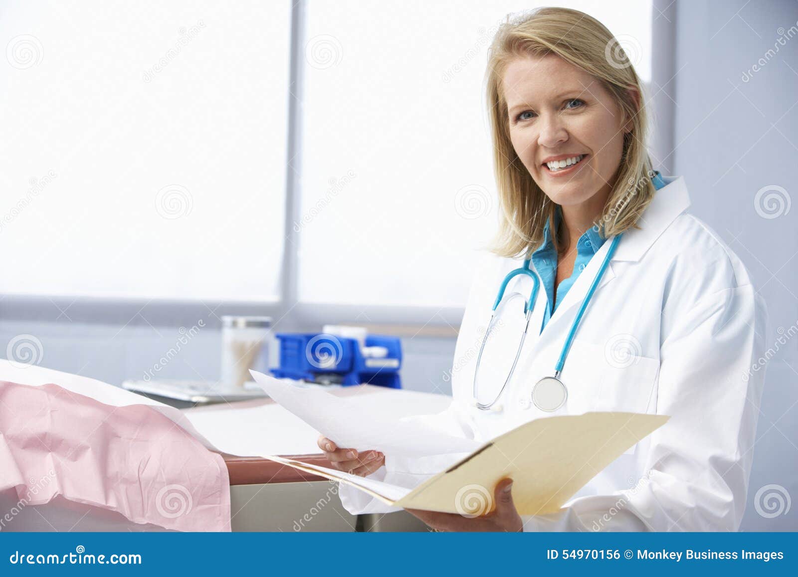 Female Doctor in Surgery Reading Patient Notes Stock Photo - Image of ...
