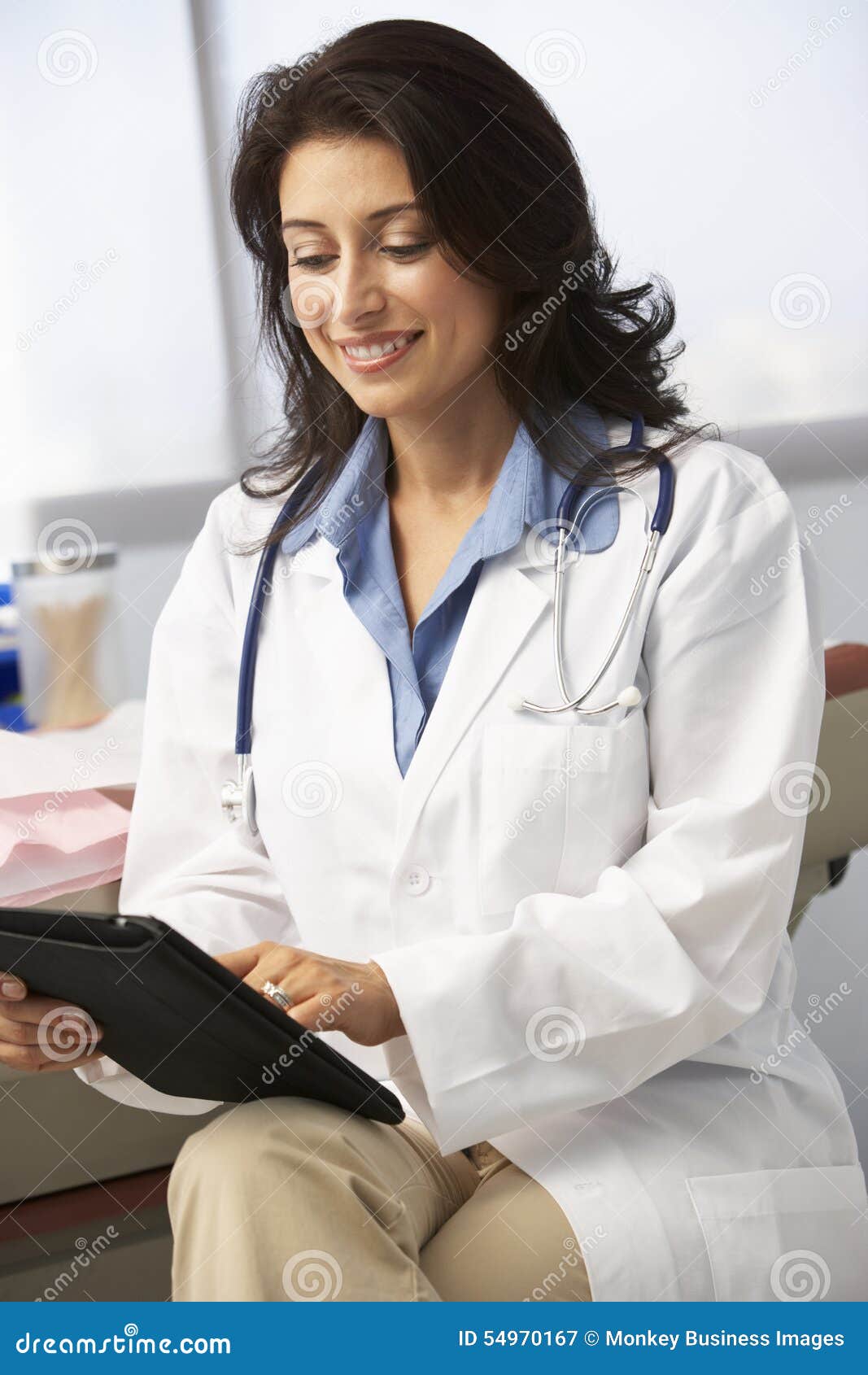 Female Doctor in Surgery Reading Patient Notes Stock Image - Image of ...
