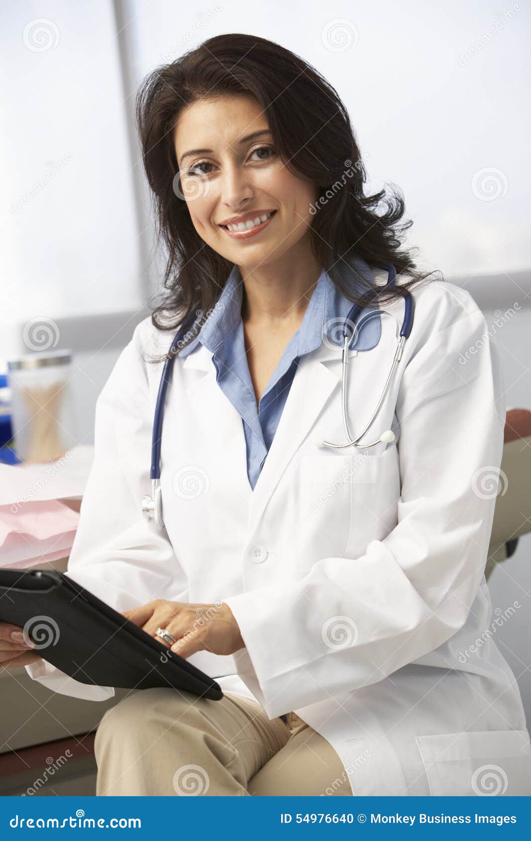 Female Doctor in Surgery Reading Patient Notes Stock Photo - Image of ...