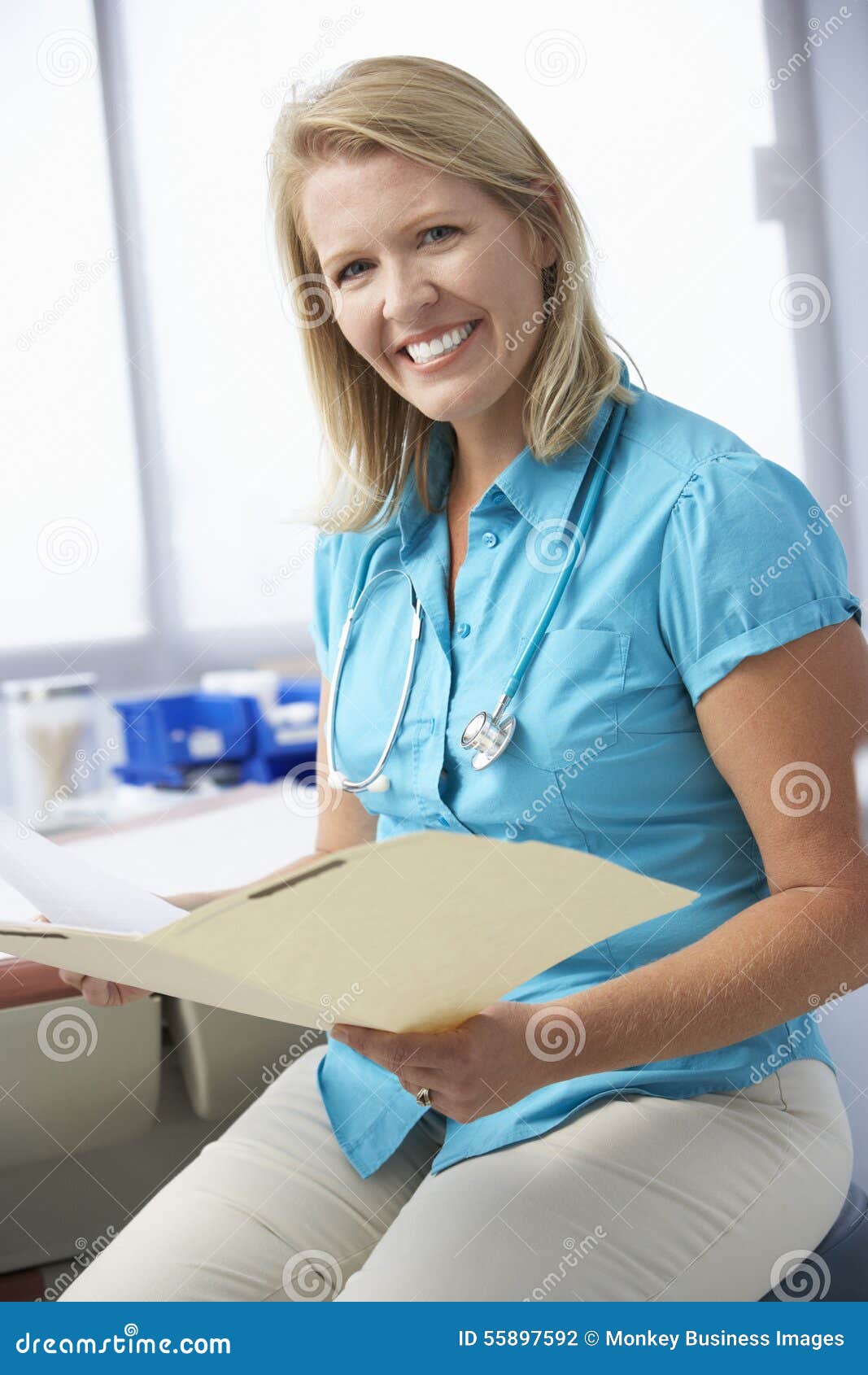 Female Doctor in Surgery Reading Patient Notes Stock Photo - Image of ...
