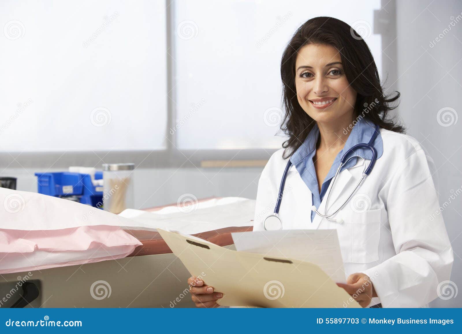 Female Doctor in Surgery Reading Patient Notes Stock Image - Image of ...