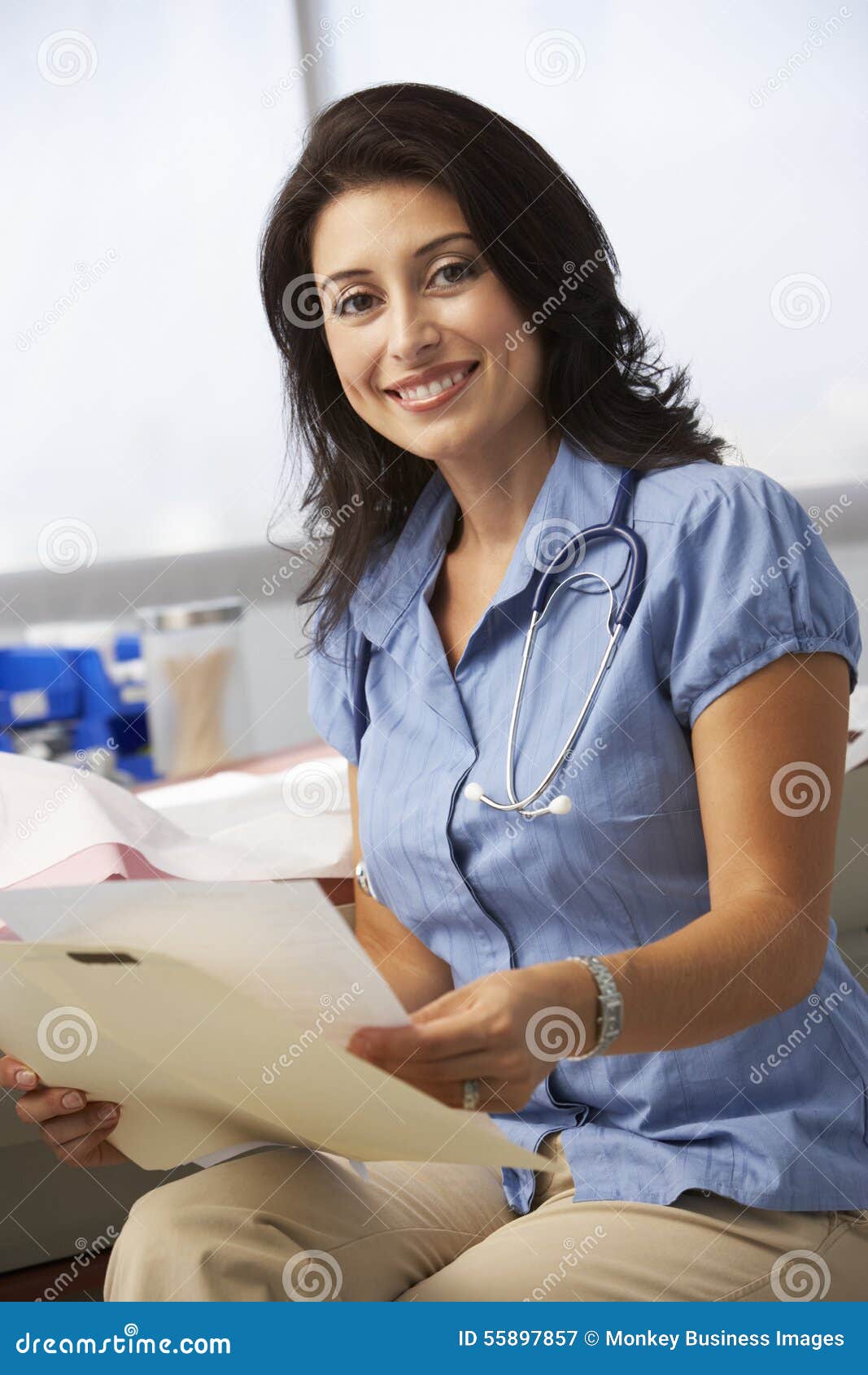 Female Doctor in Surgery Reading Patient Notes Stock Image - Image of ...