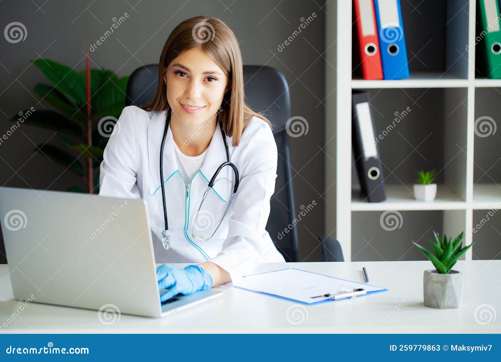 Female Doctor in Surgery Reading Patient Notes on Laptop Stock Image ...