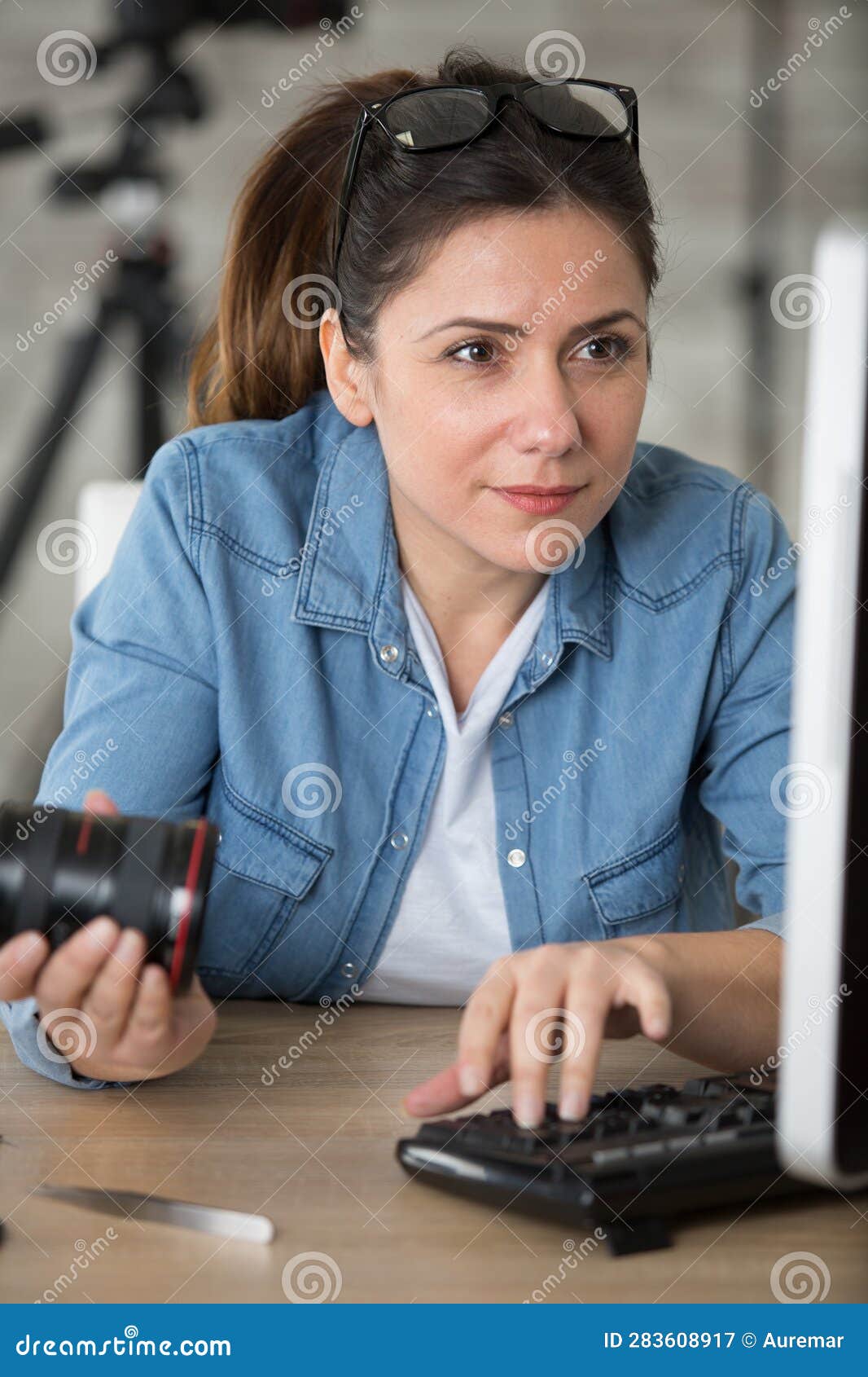 Female Editor Holding Camera Lens and Using Computer Stock Image ...
