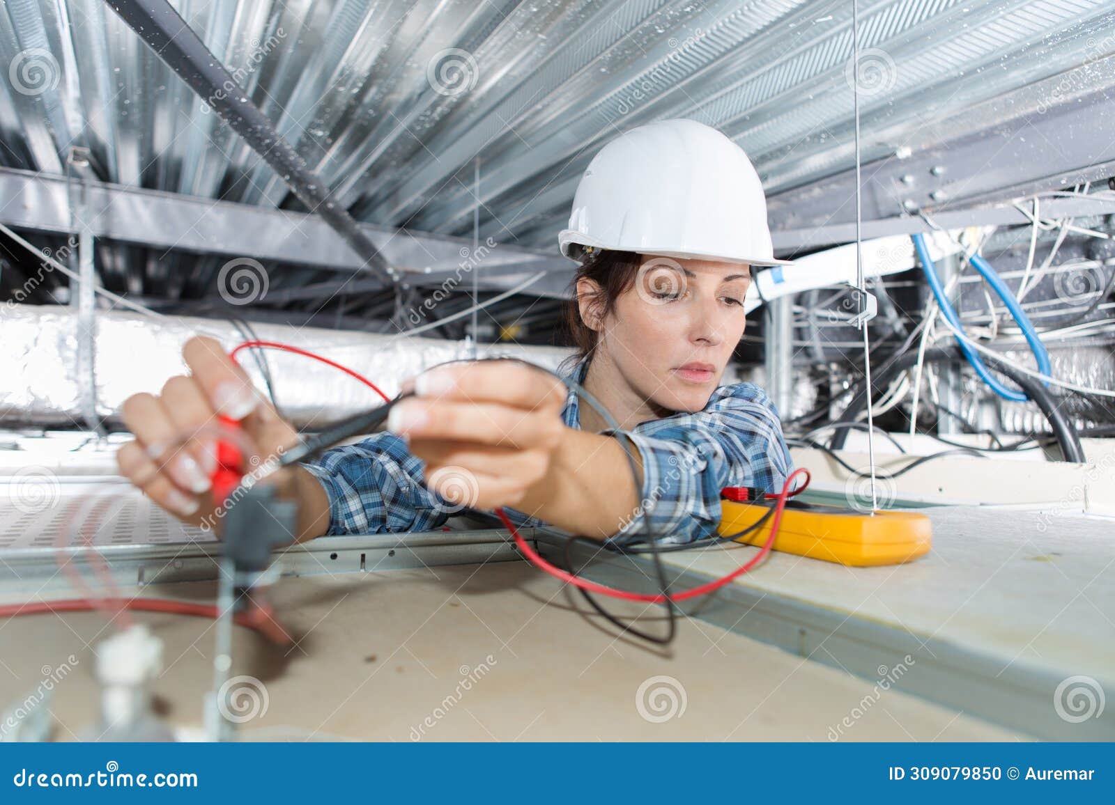 Female Electrician Using Multimeter To Test Spotlight Stock Photo ...
