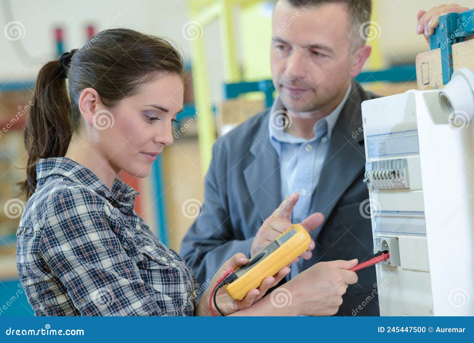 Female Electrician Using Multimeter Under Supervision Stock Photo ...